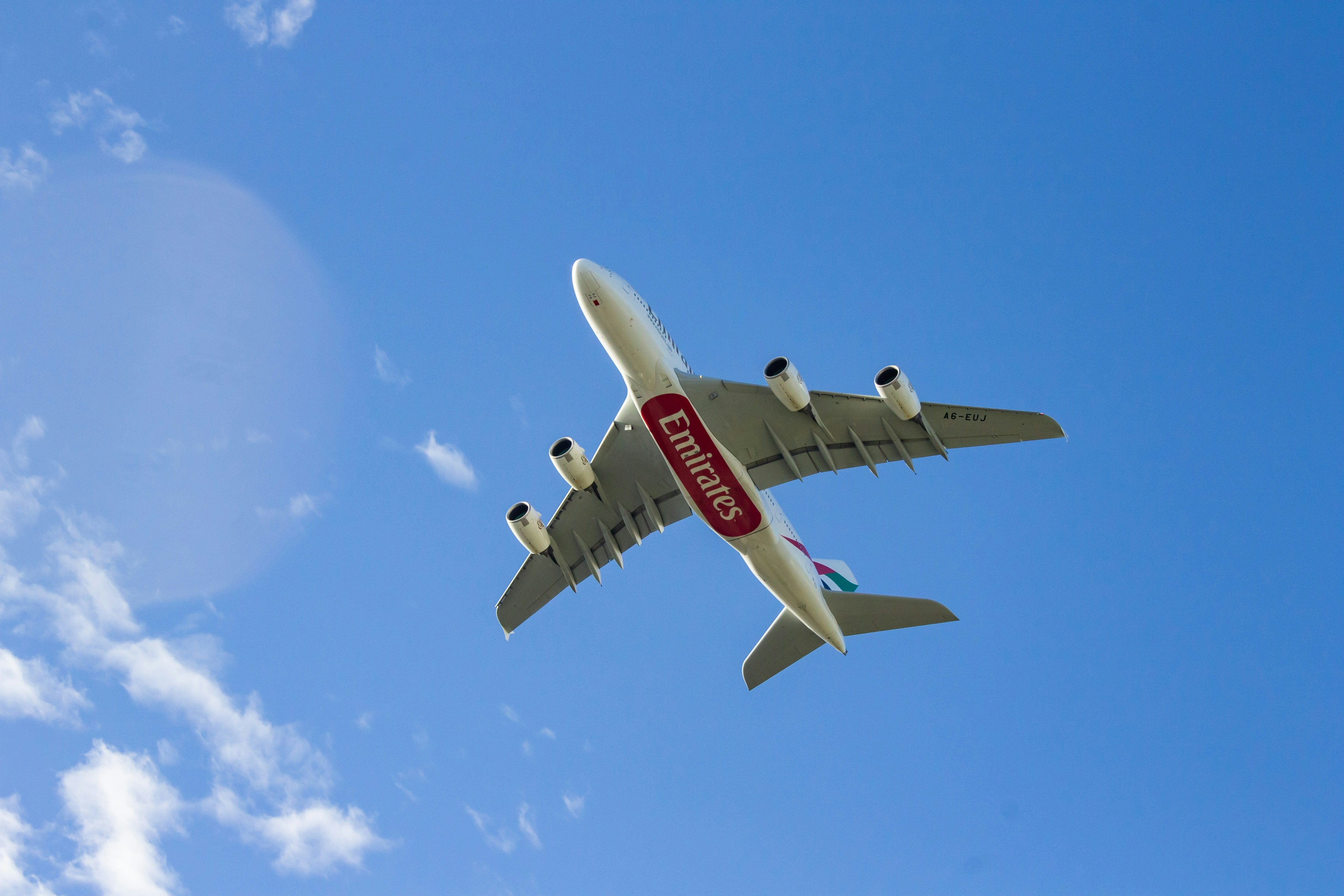Azure Acro: Emirates four-engine jet carving a diagonal arc through the sky
