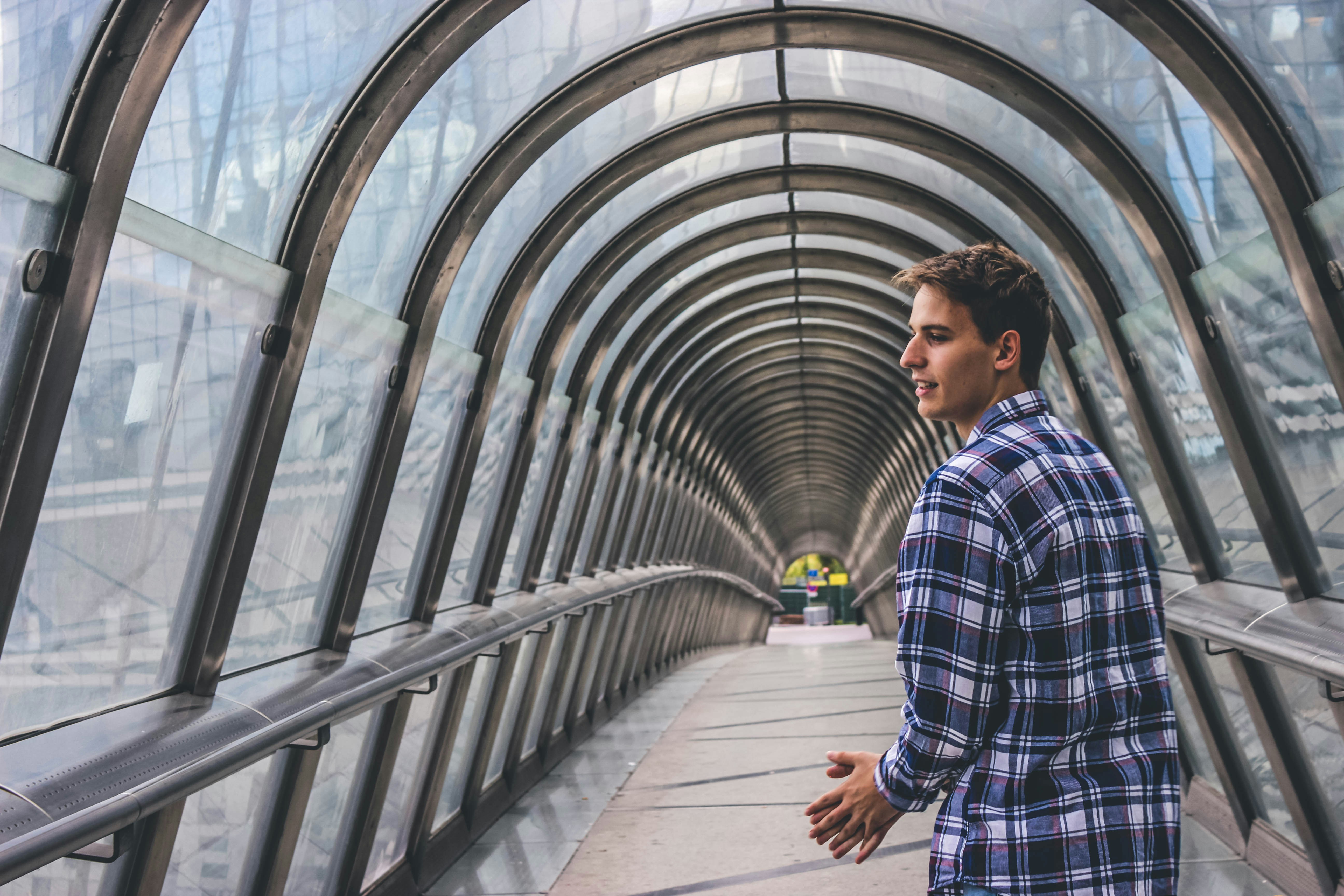 Man walking through glass arch pathway photo – Free La défense Image on ...