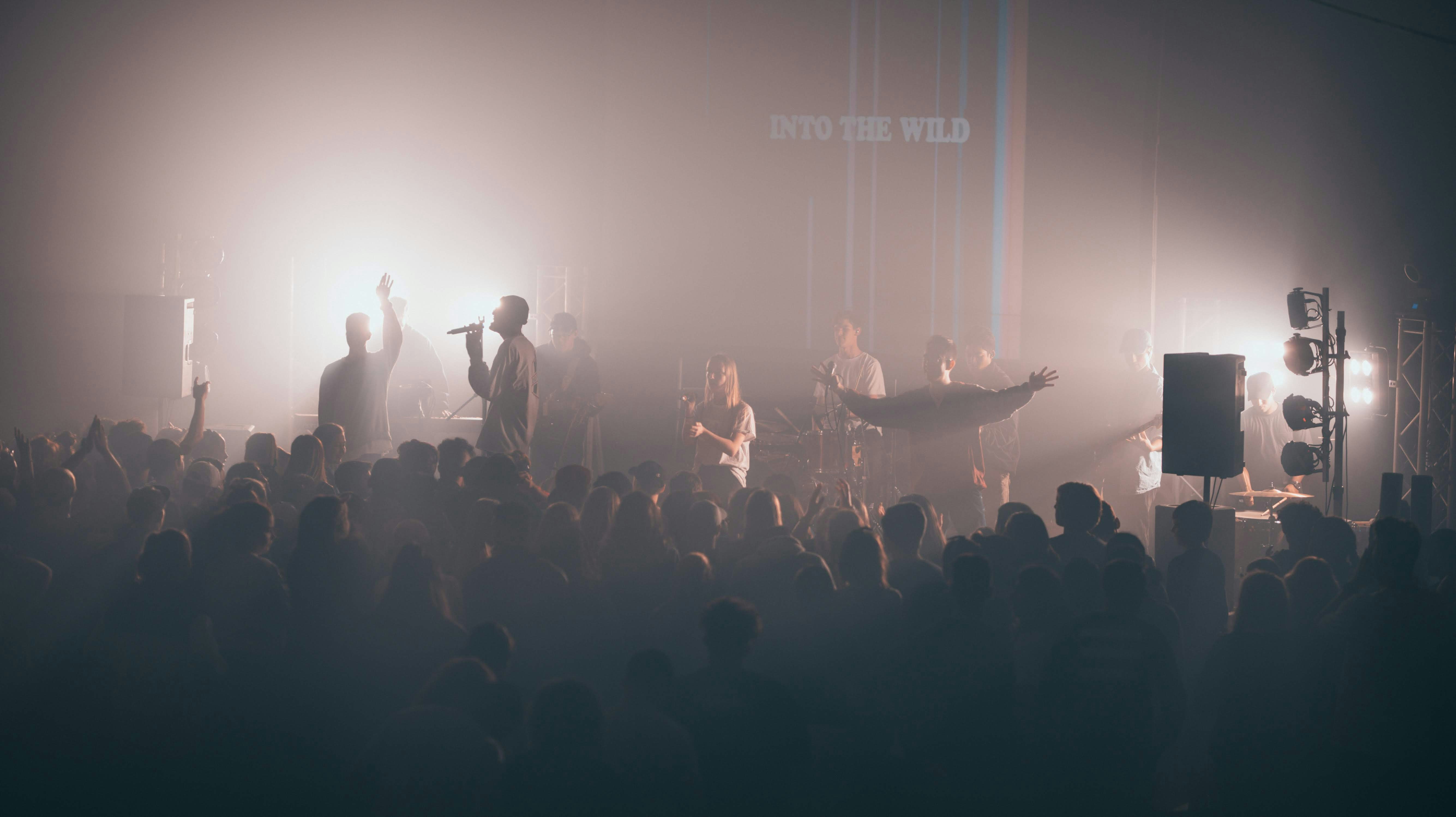 Several people performing on stage in front of crowd photo – Free Fog ...