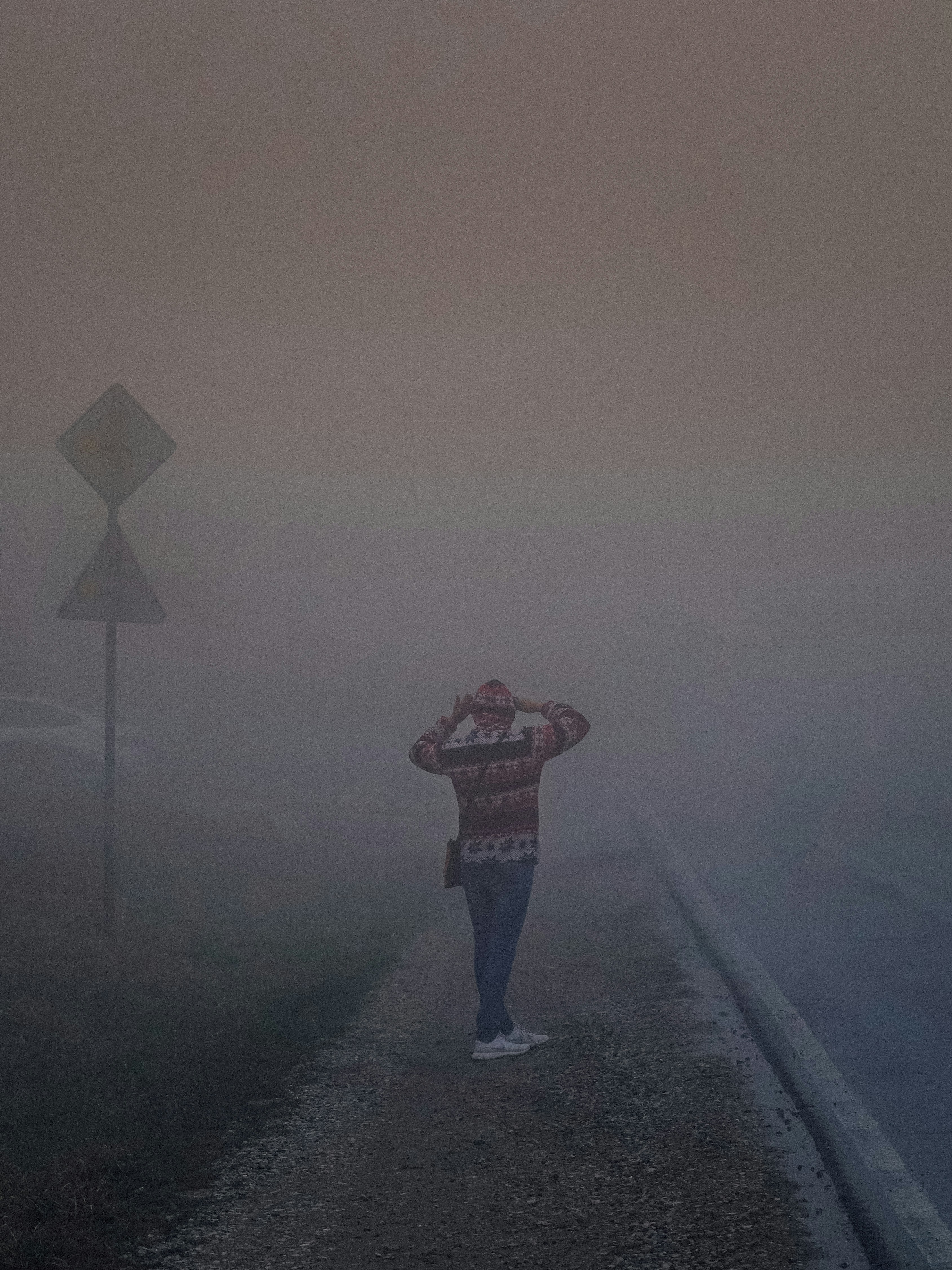 Mistbound Mile: A Lone Figure on a Fog-Washed Road