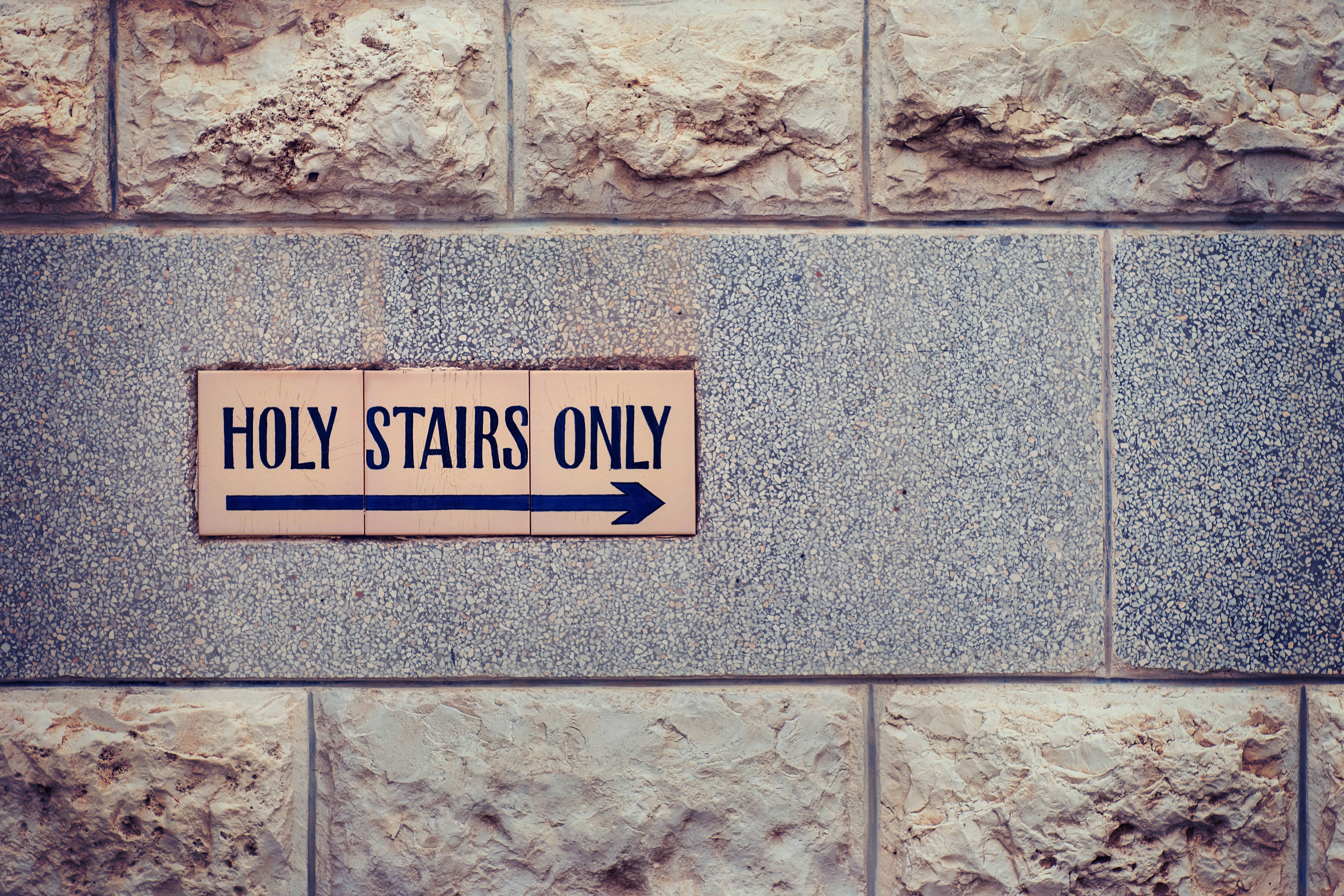 Holy Stairs Only: A Sharp Sign on a Textured Stone Facade