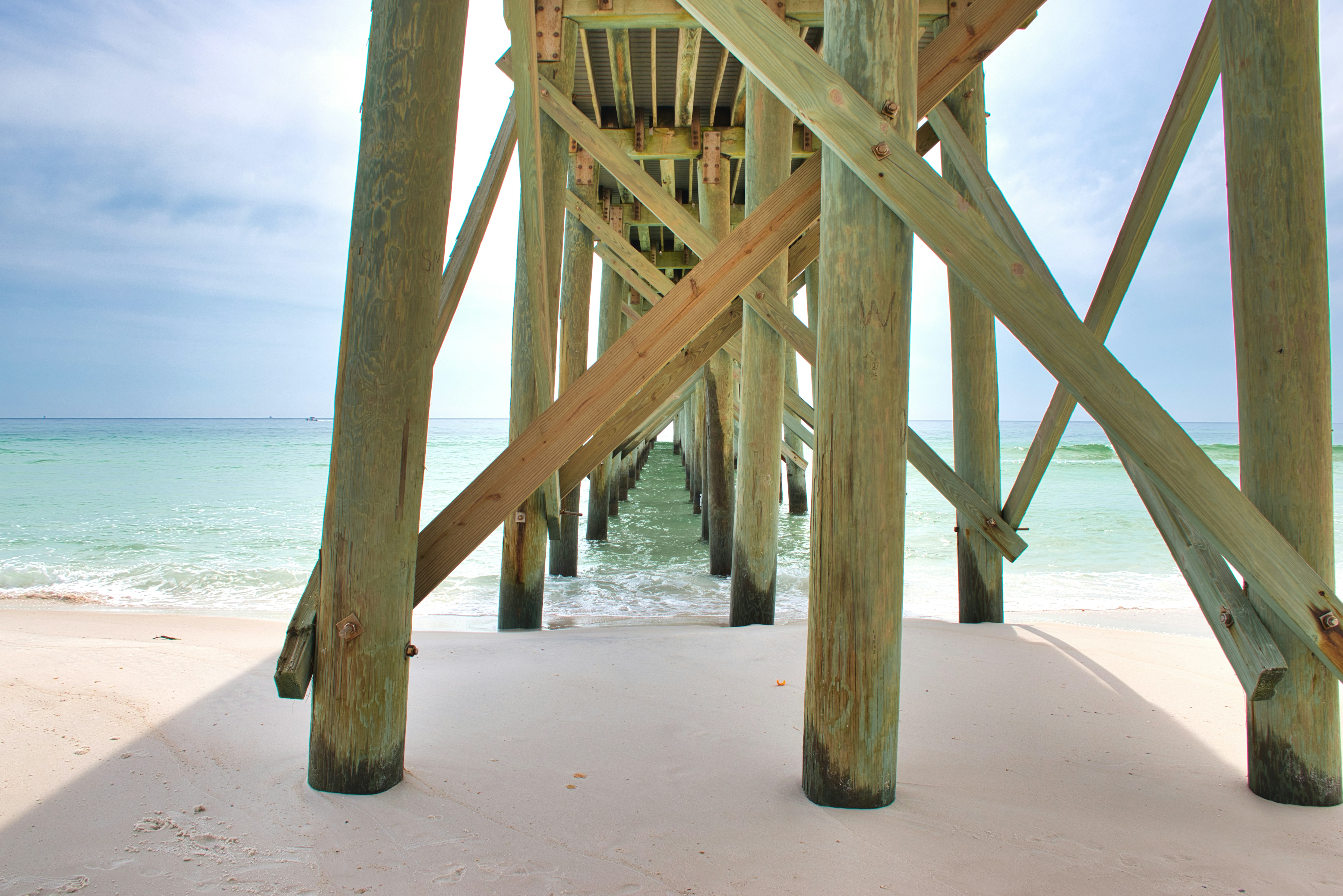Under the Pier: A Corridor of Sea-Sky Between Weathered Timbers