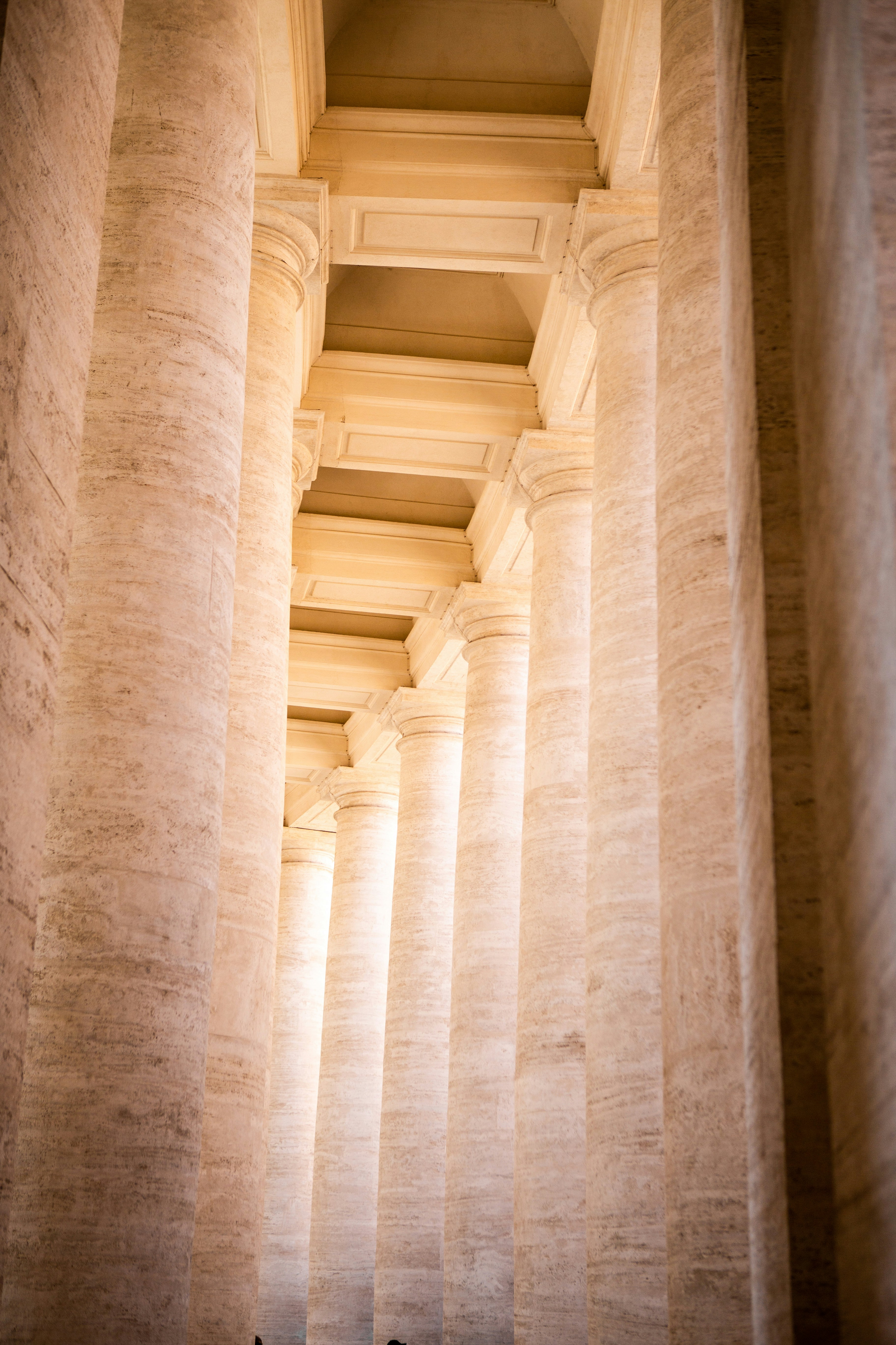 A group of people standing next to each other under columns photo ...