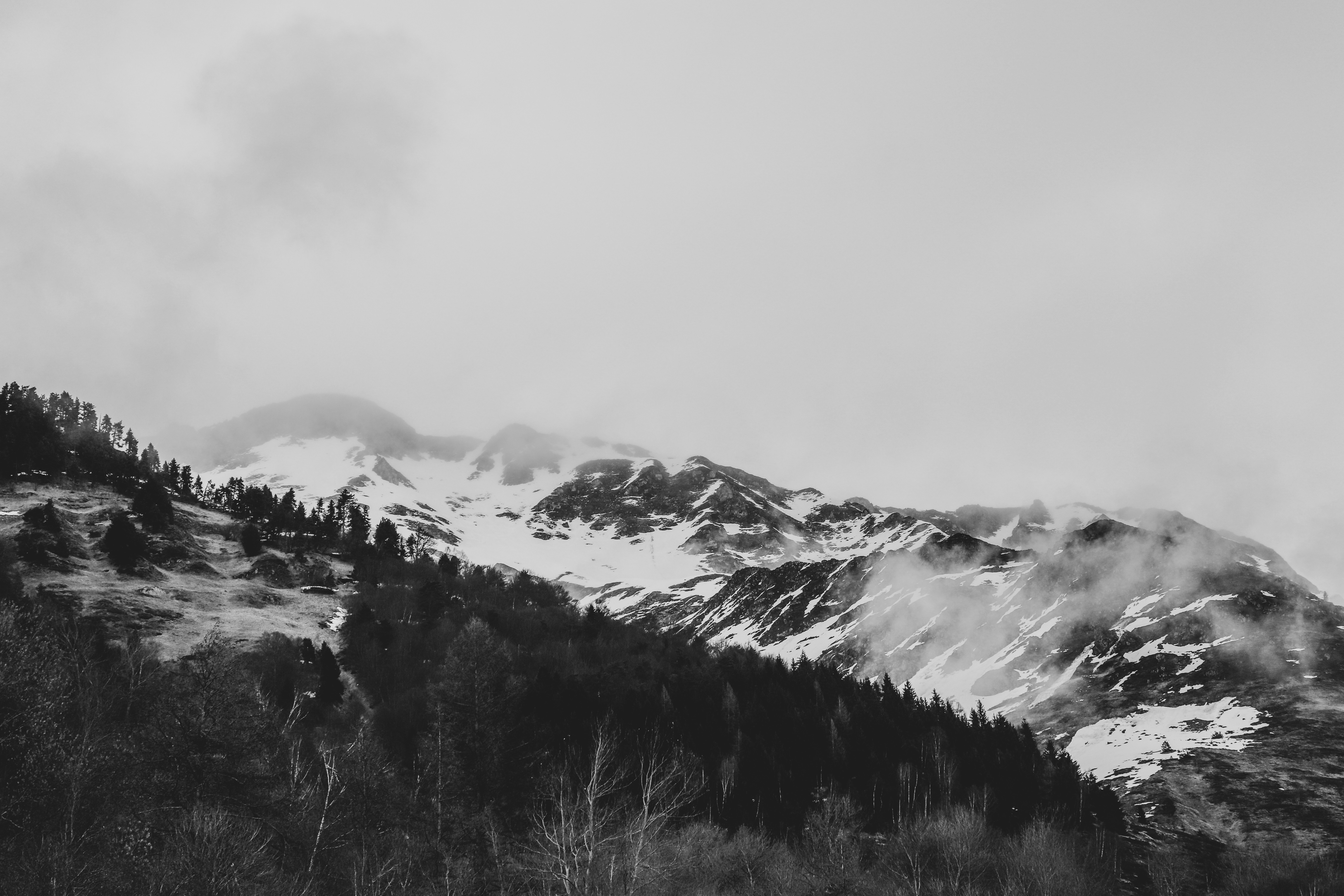 Snow-dusted mountain peaks beneath a cloudy gray sky.