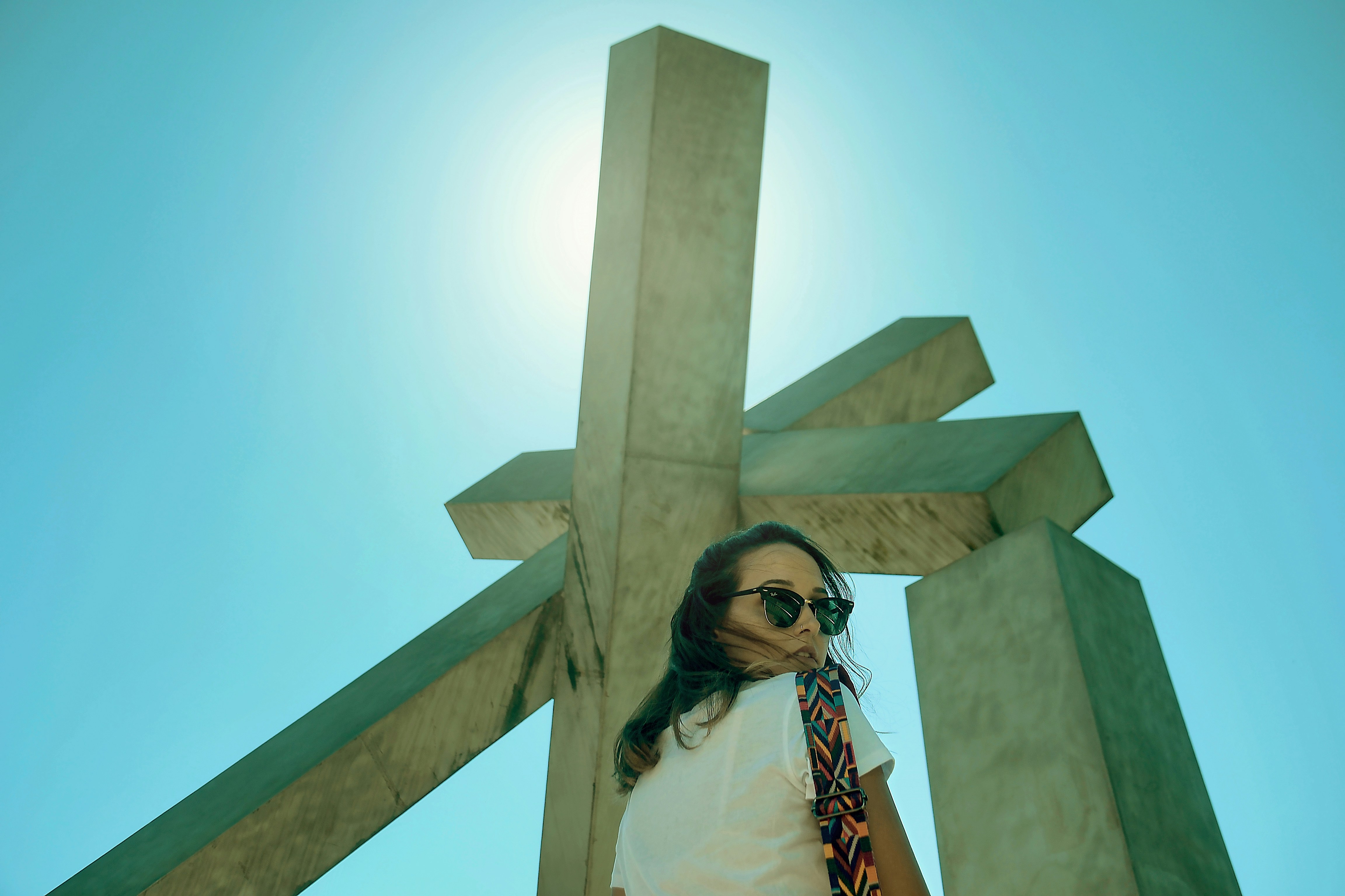 Between Stone and Sky: Portrait Framed by a Looming Concrete Cross