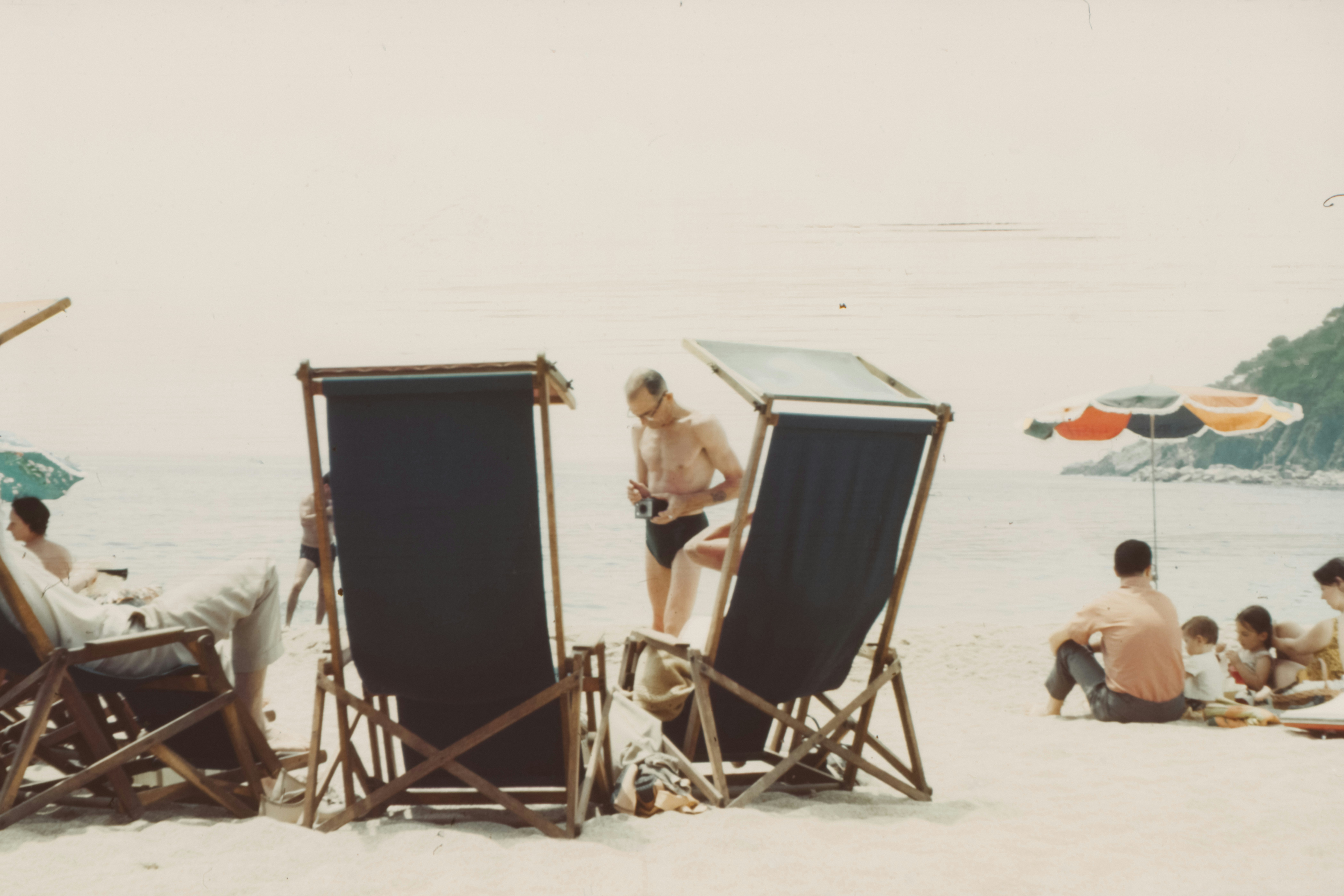 Between Shade and Shore: A Quiet Beach Moment Framed by Lounge Chairs