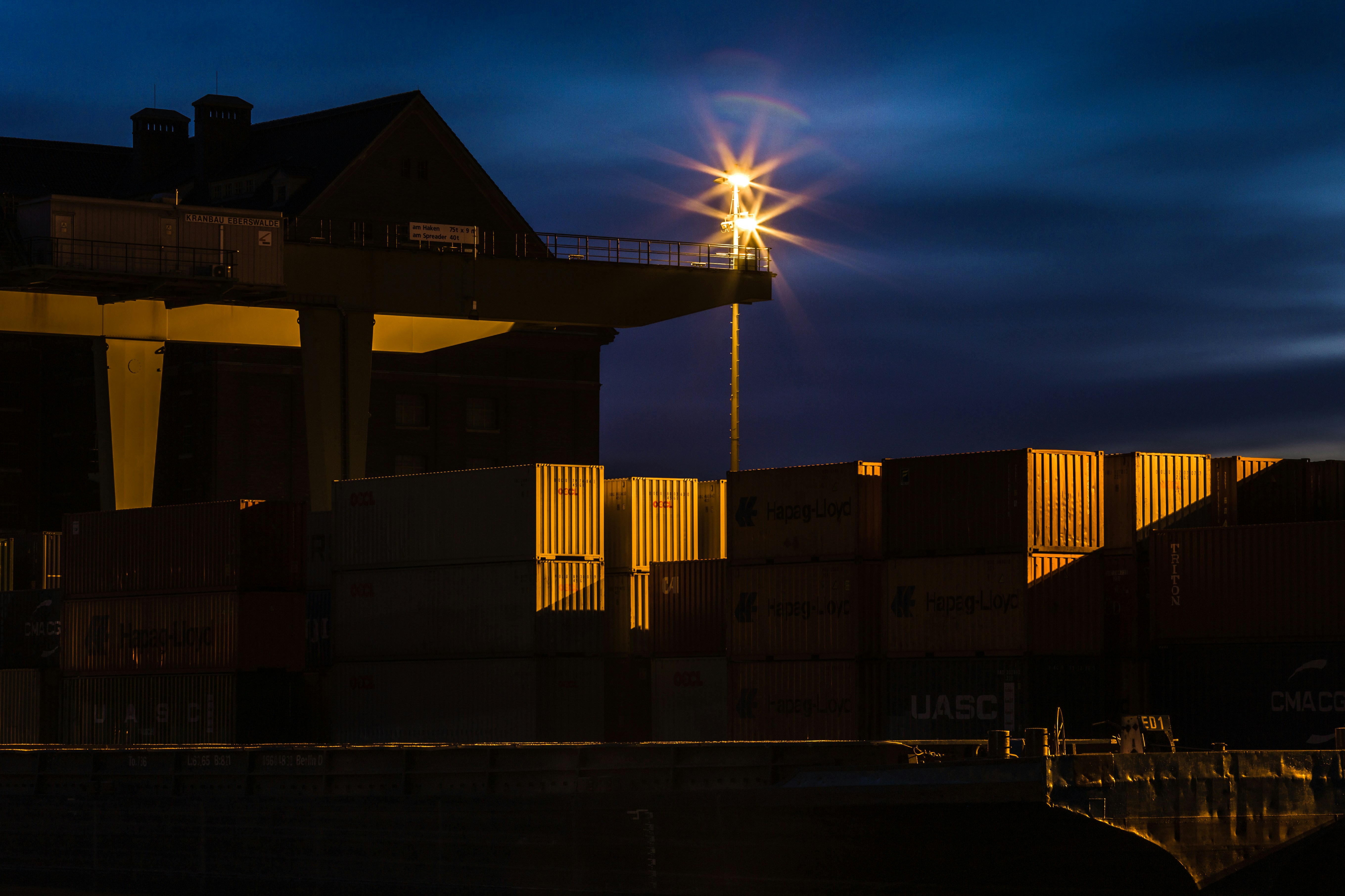 Beacon Over Stacked Freight: Dusk at the Container Pier
