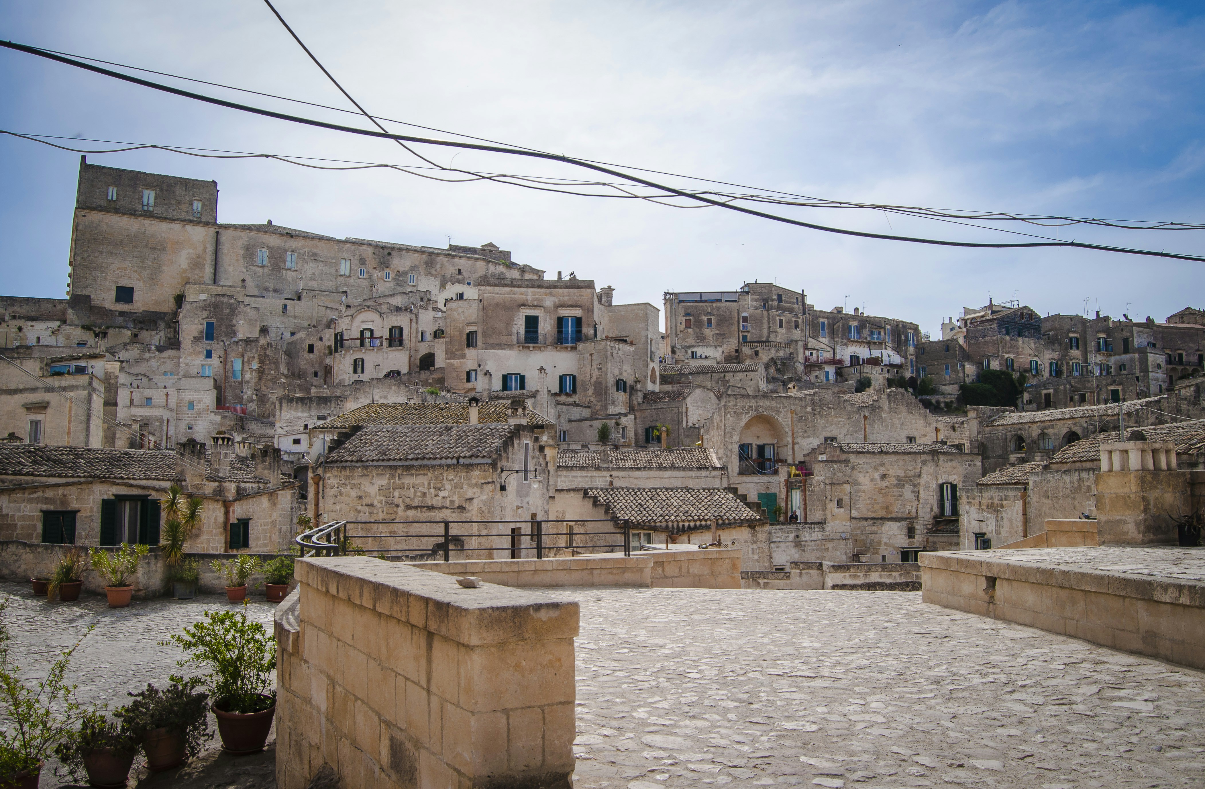 Historic stone buildings clustered on a hillside under a clear blue sky.