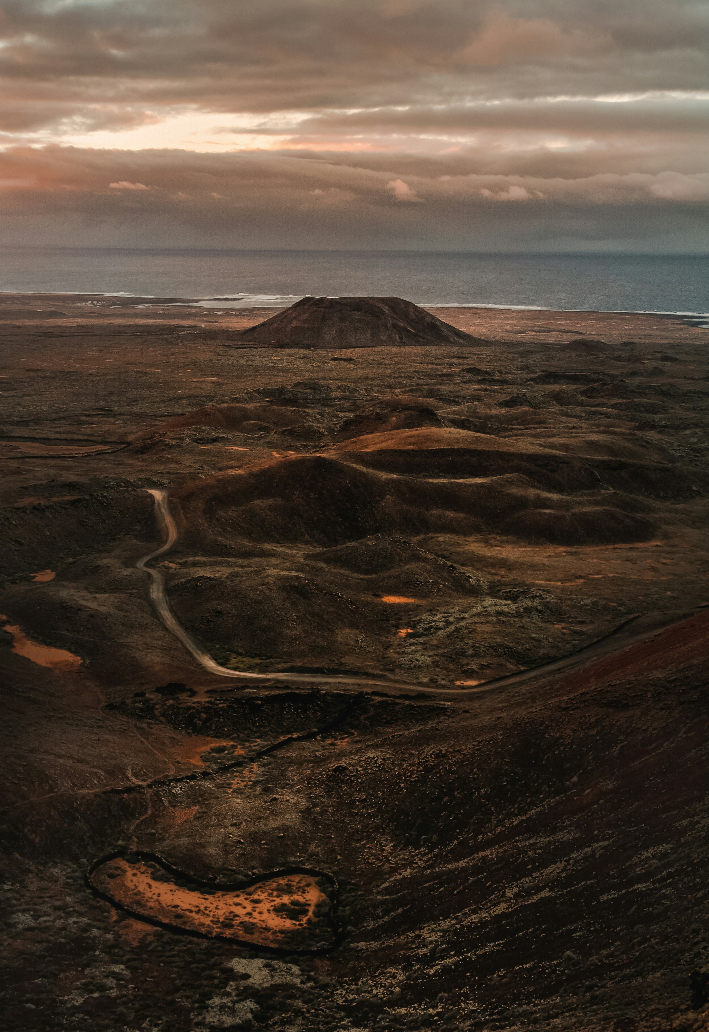 Dusk Over the Lava Plain: A Lone Hill Guards the Sea