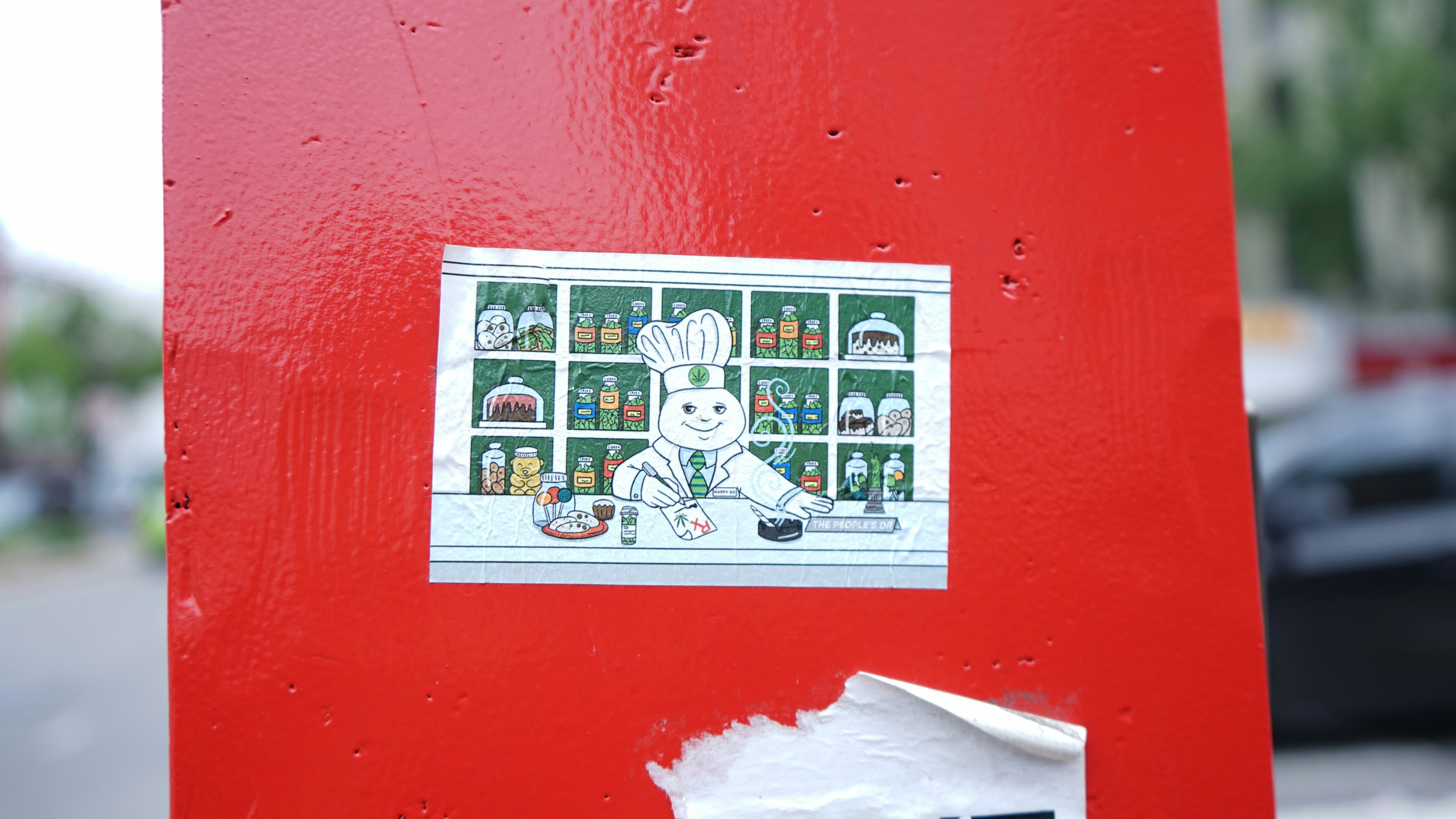 Crimson Street Pole Hosts a Cartoon Chef Sticker