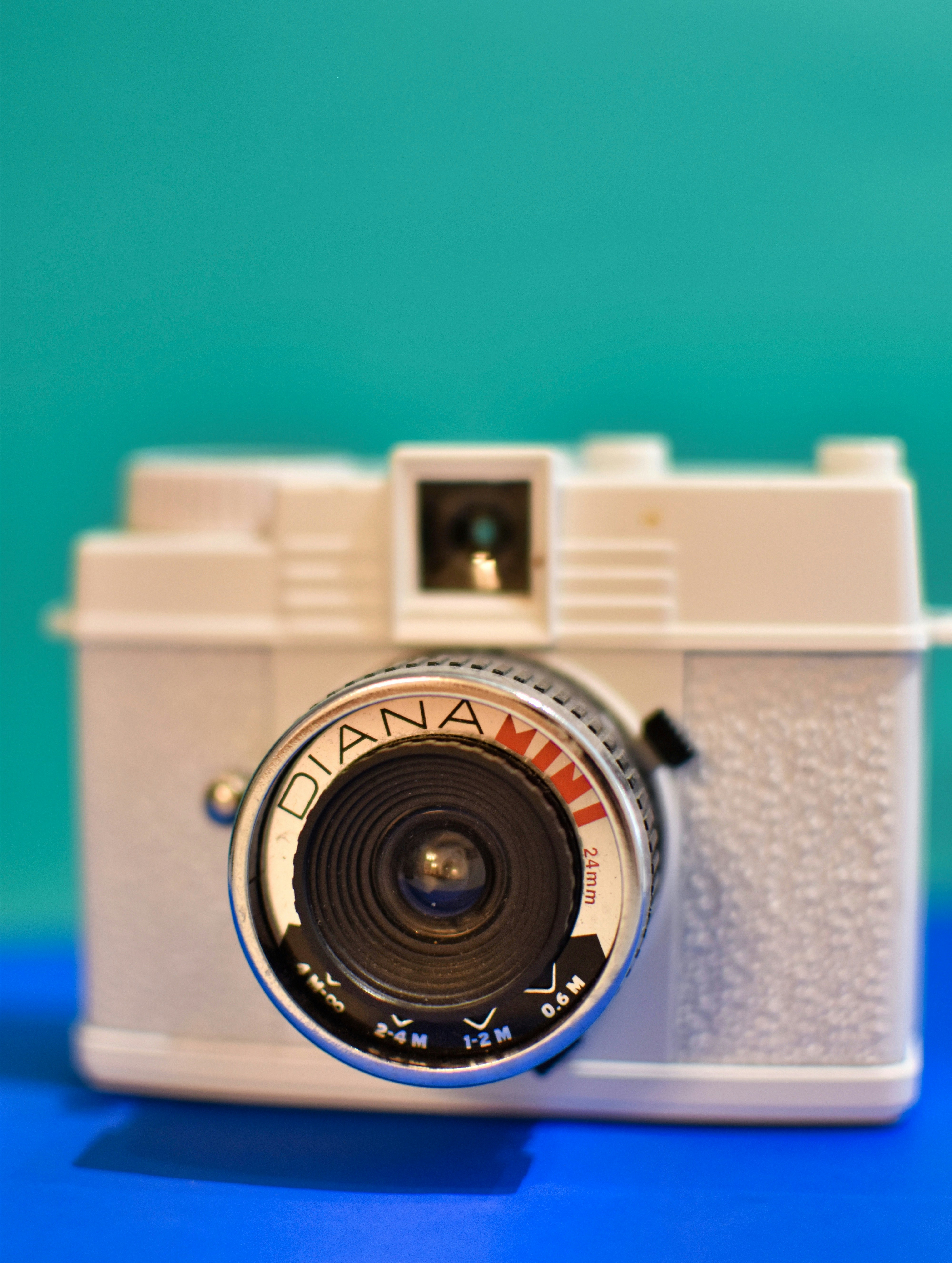 White and black Diana Mini camera on blue surface photo – Free Portrait ...