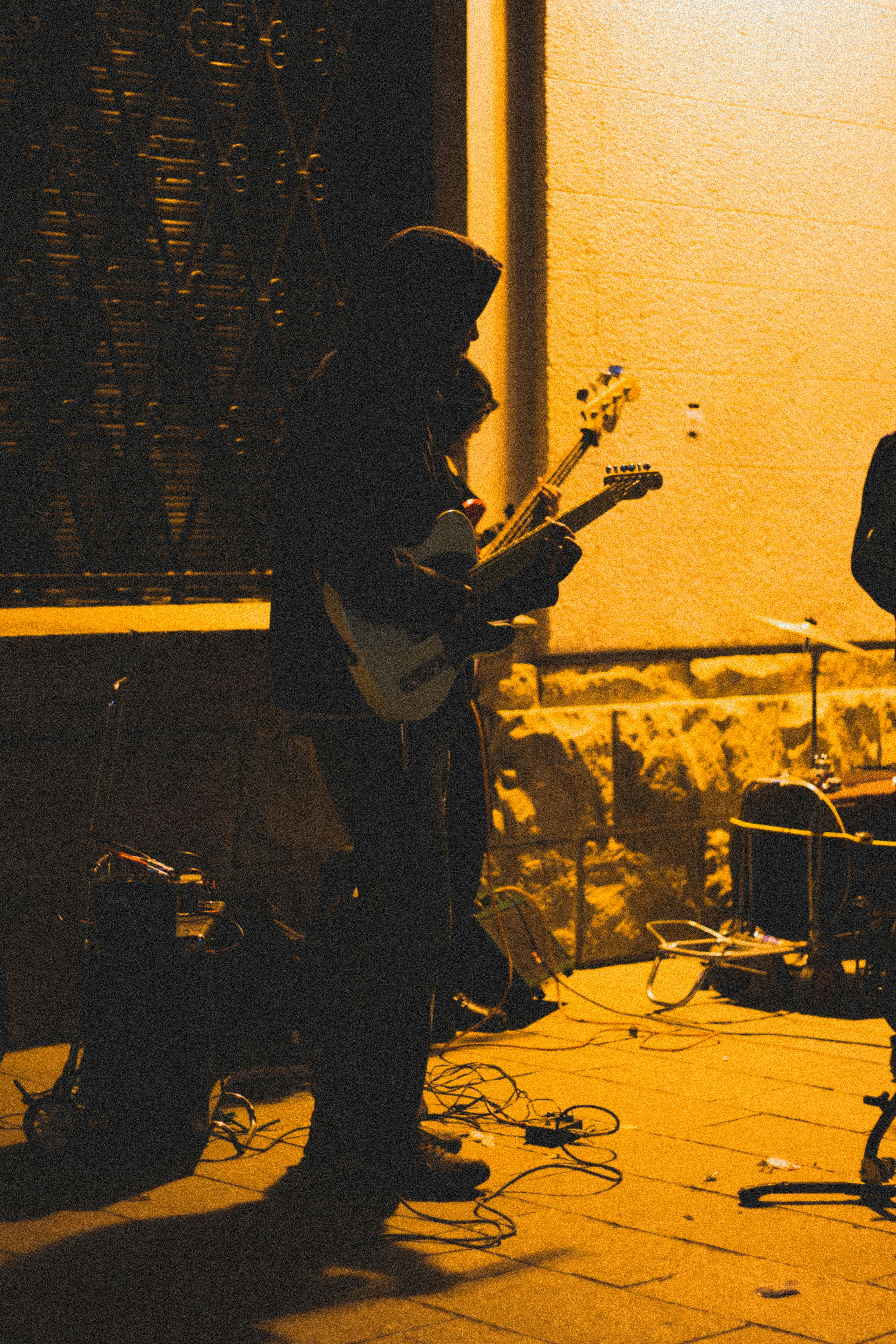 Amber Street Serenade: Silhouetted Guitarist Under Warm Nightlight