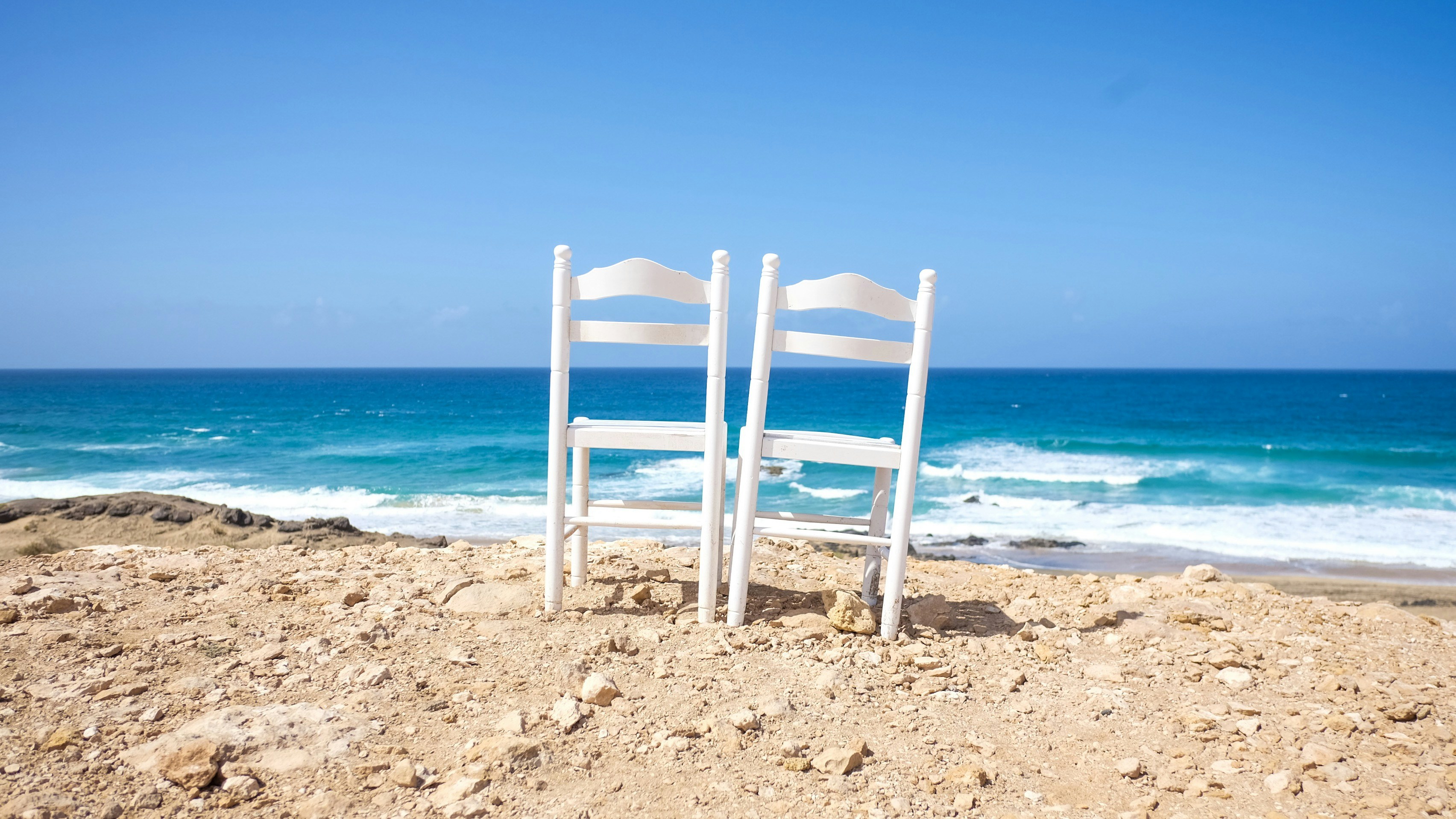 white wooden chairs on shore