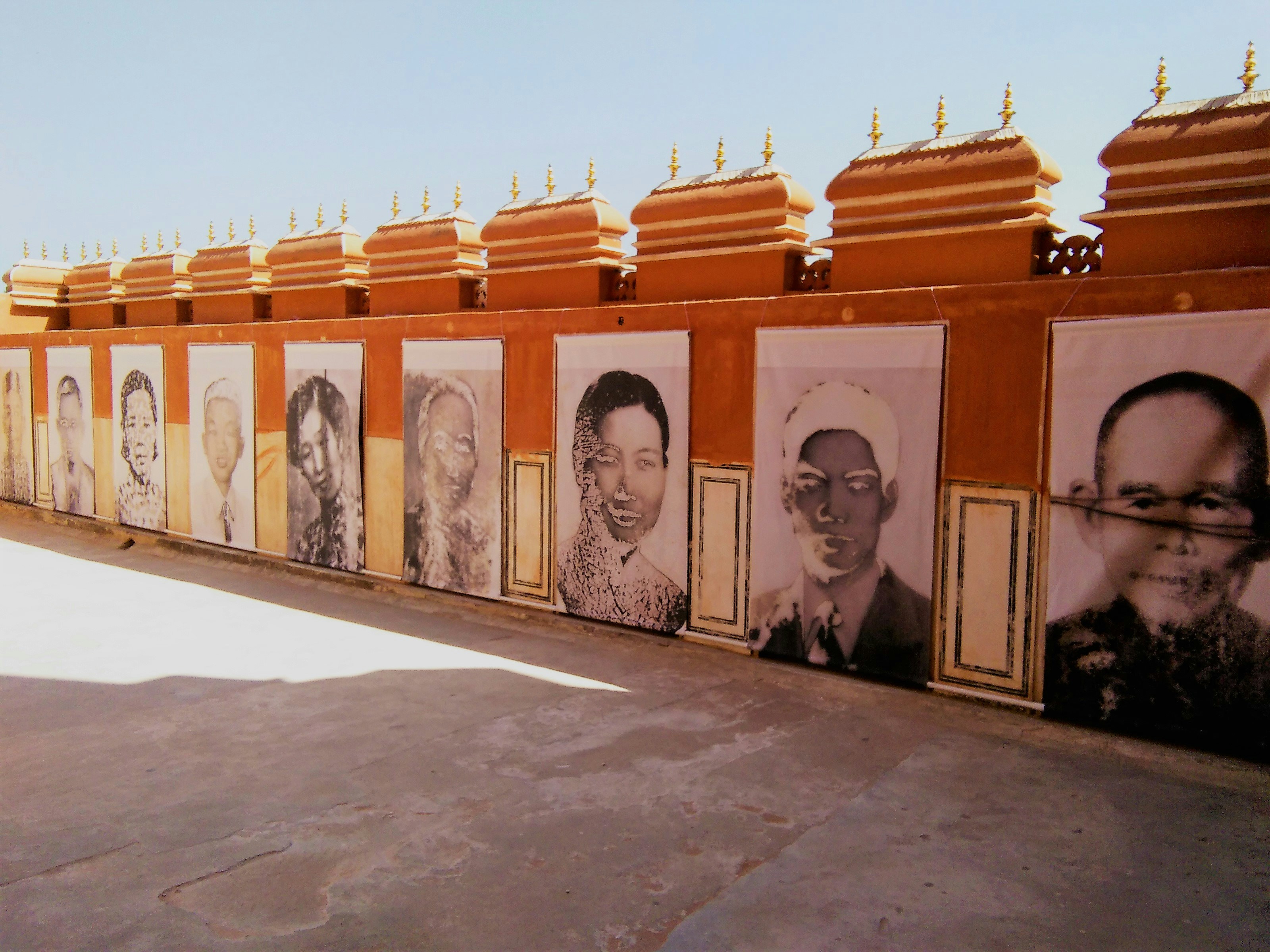 Gallery of Faces on Sunlit Wall