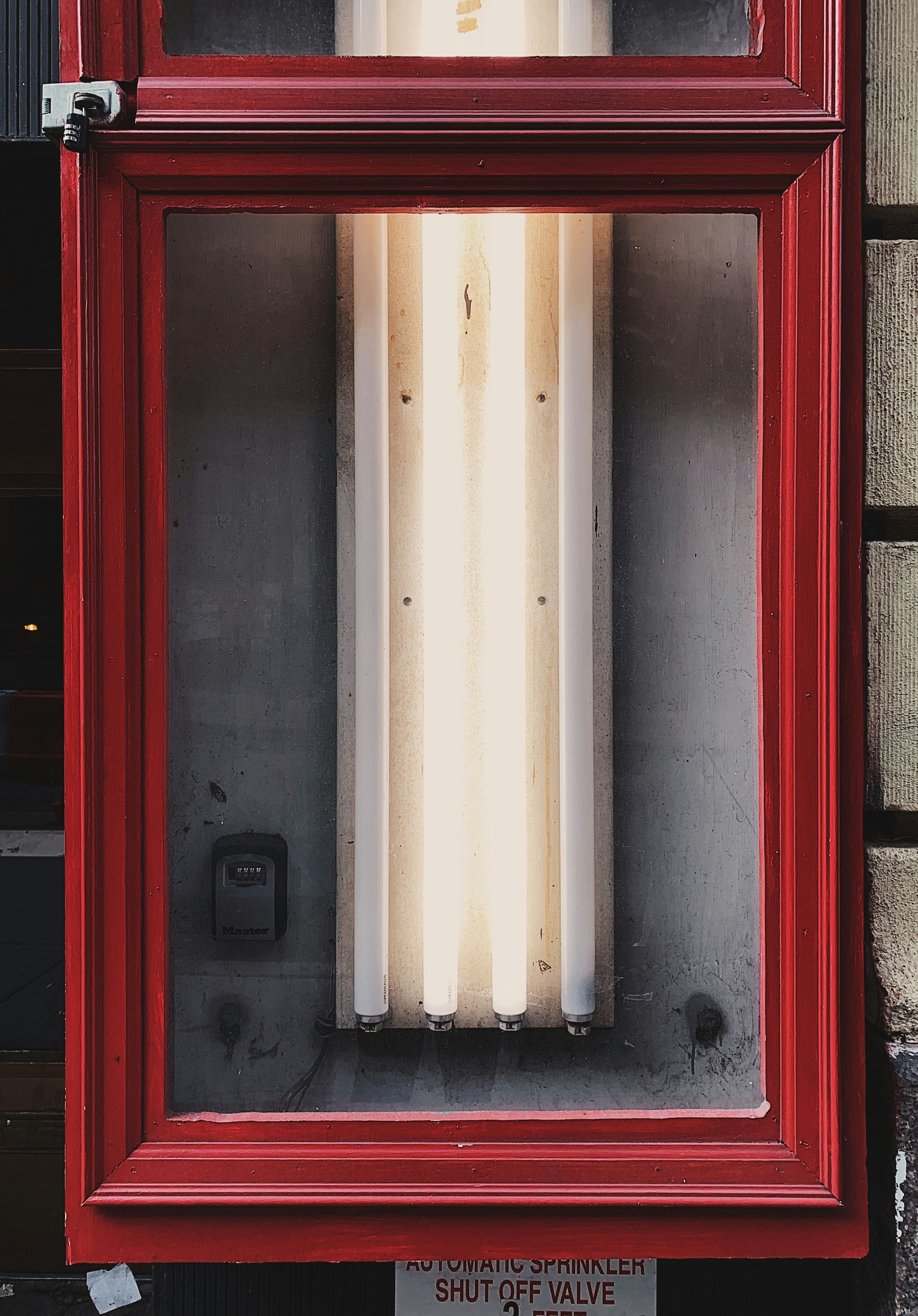 Crimson Frame, Neon Core: Vertical Light in a Narrow Window