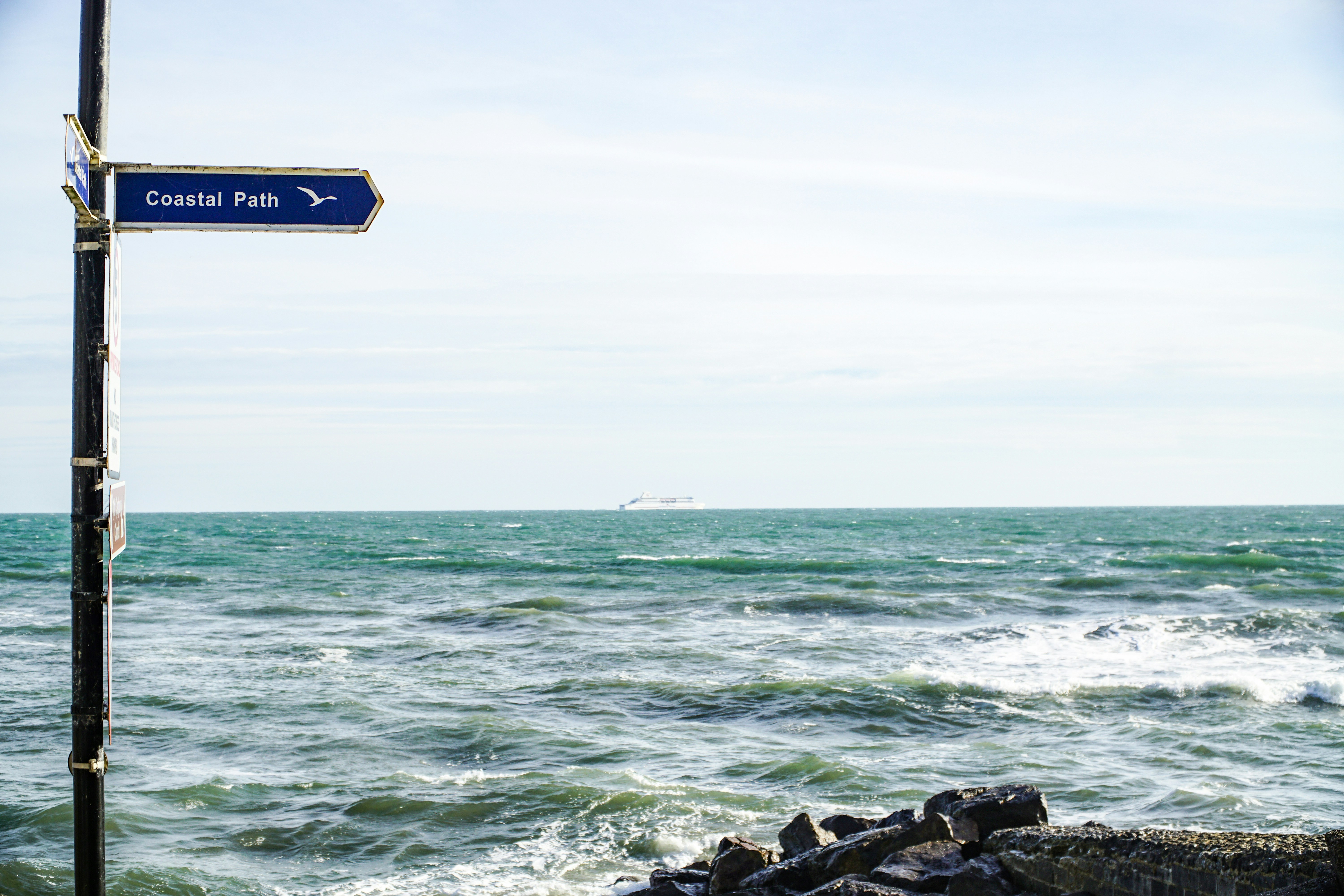 Coastal Signpost Overlooking Distant Horizon
