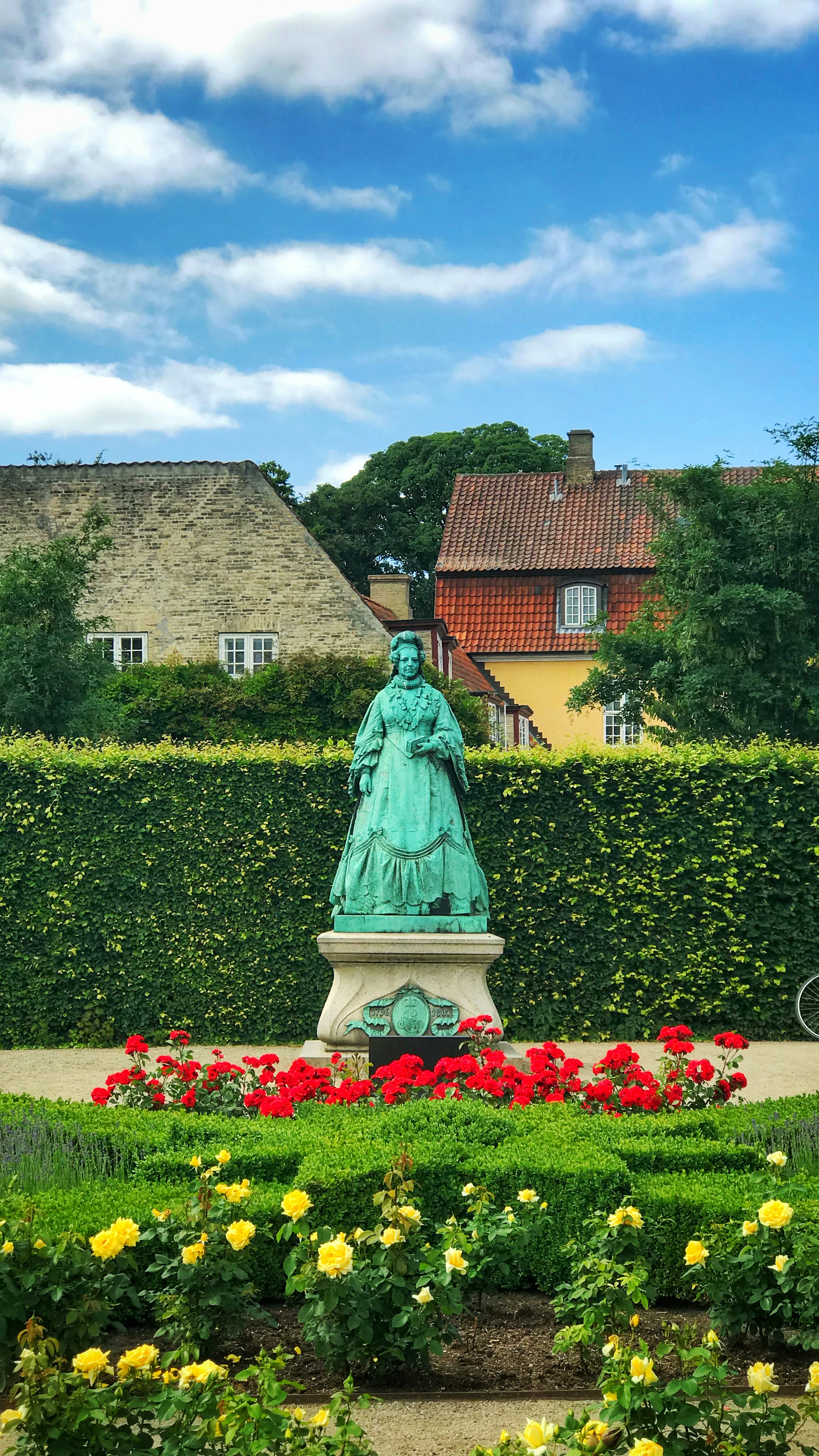Patina Verdigris Statue Surrounded by Rosebeds in a Sunlit European Garden