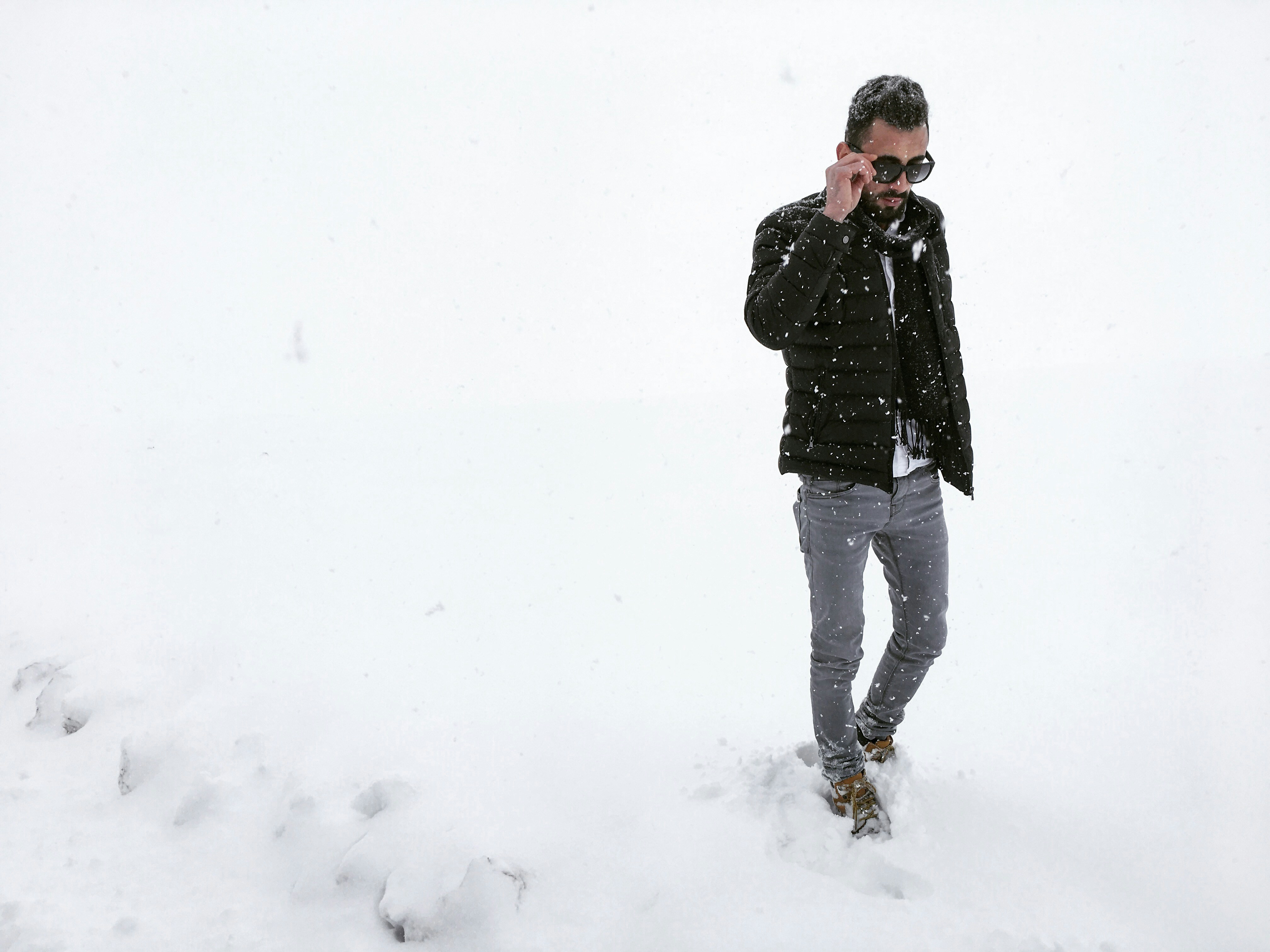 Edge of White: A Dapper Figure Traversing Snowfall