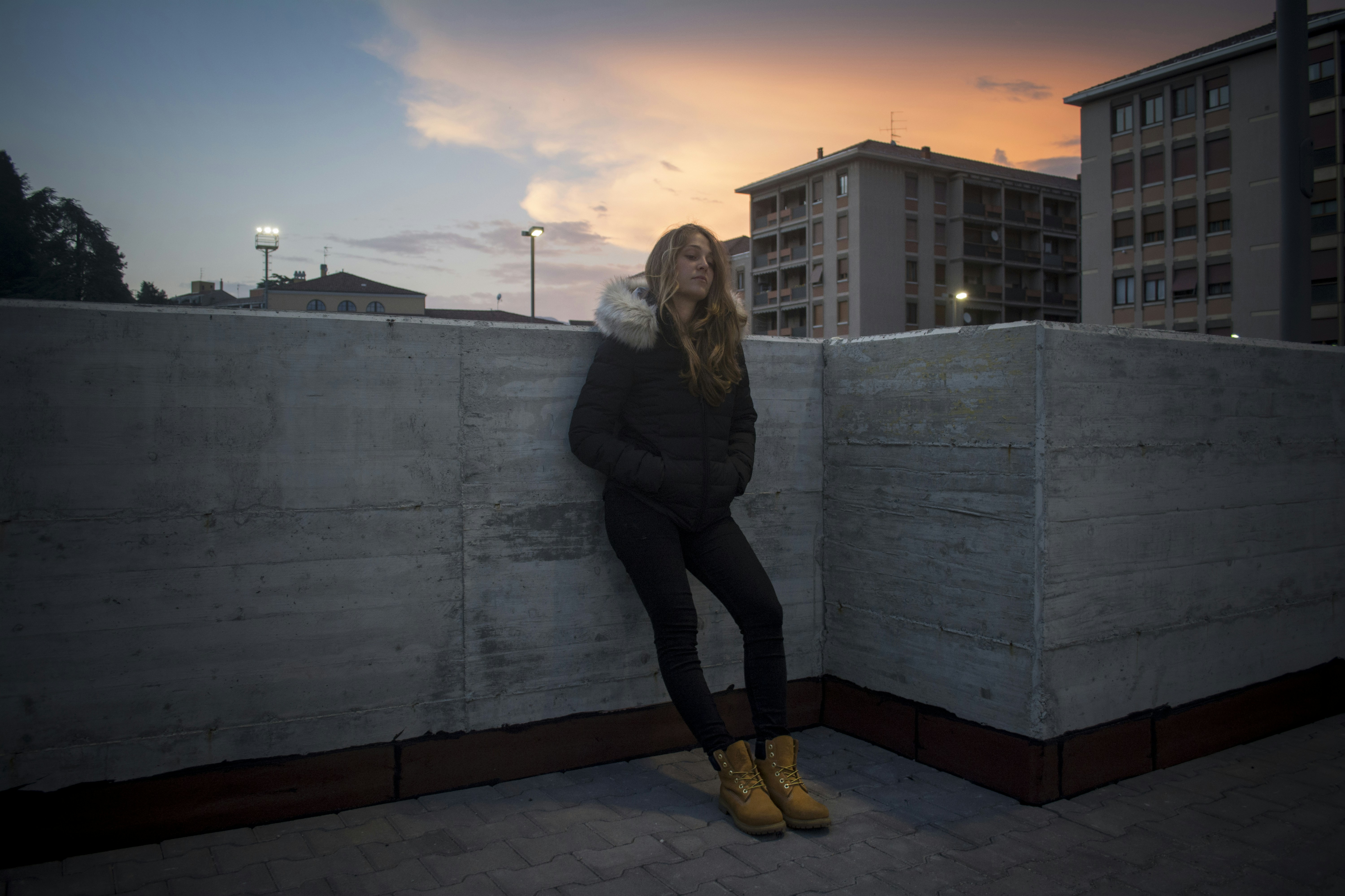 Rooftop Quiet: A Woman in a Fur-Cinted Hoodie at Dusk