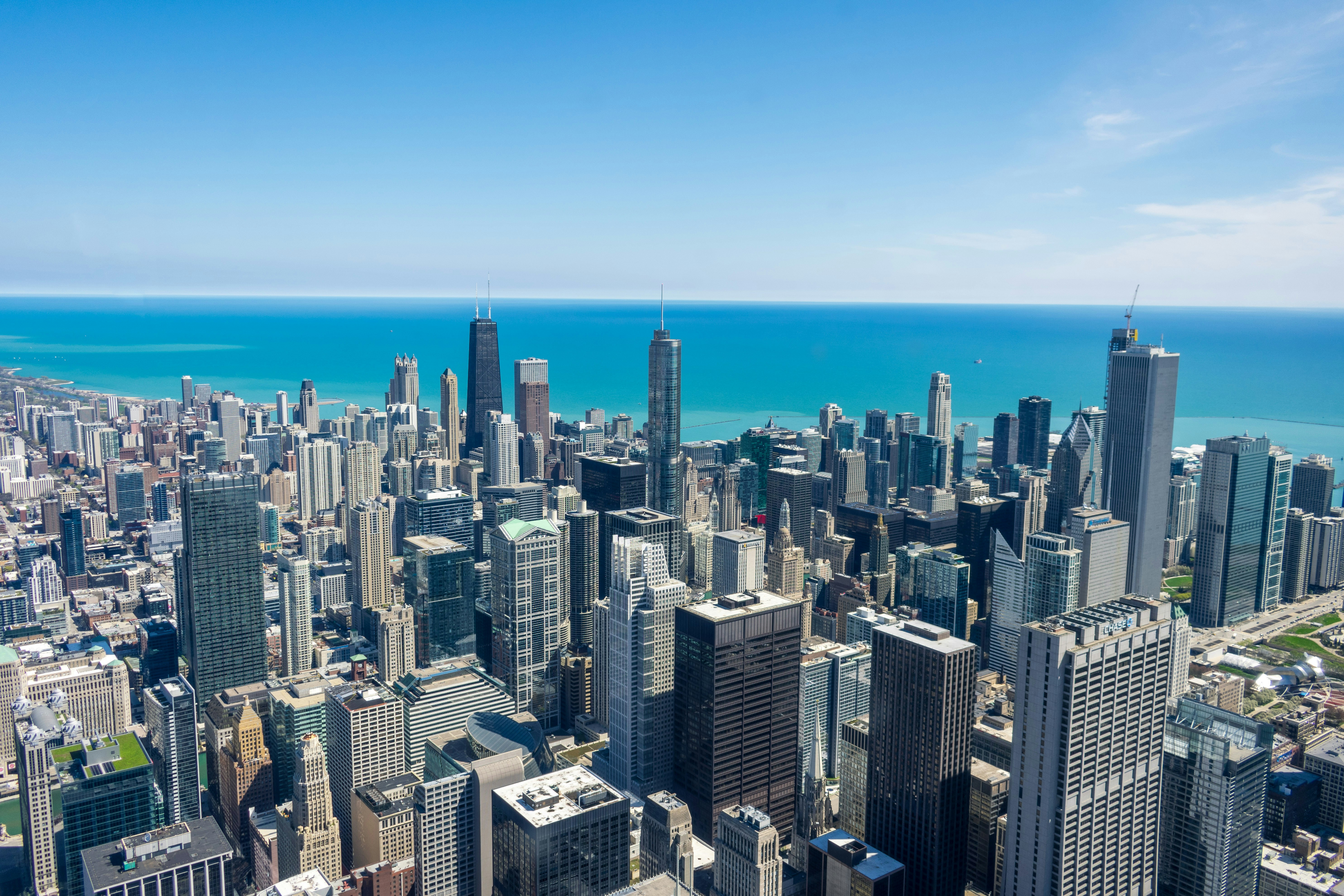 High-rise cityscape with towering buildings against a backdrop of blue lake and sky.