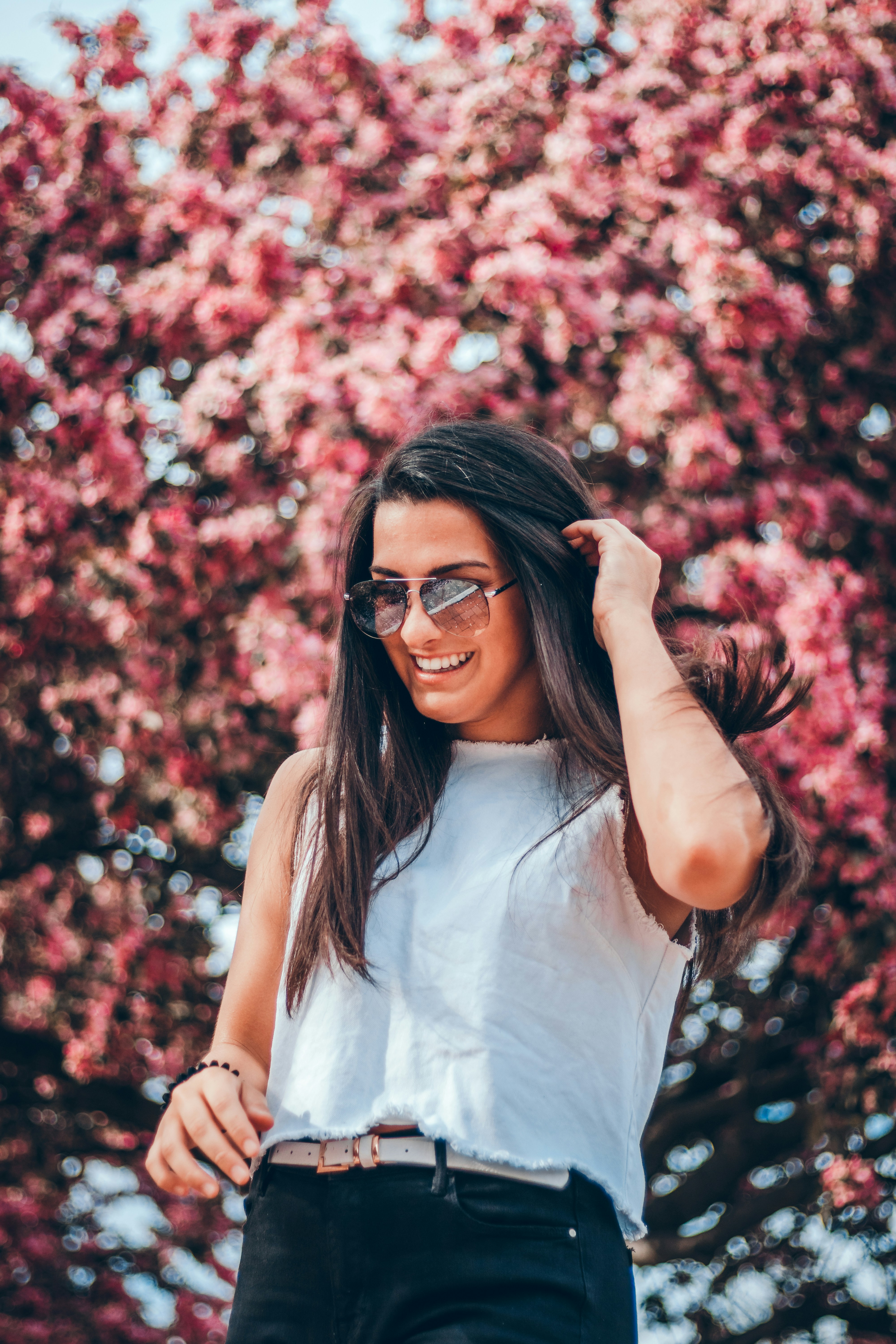 Femme souriante tenant ses cheveux tout en se tenant debout photo ...