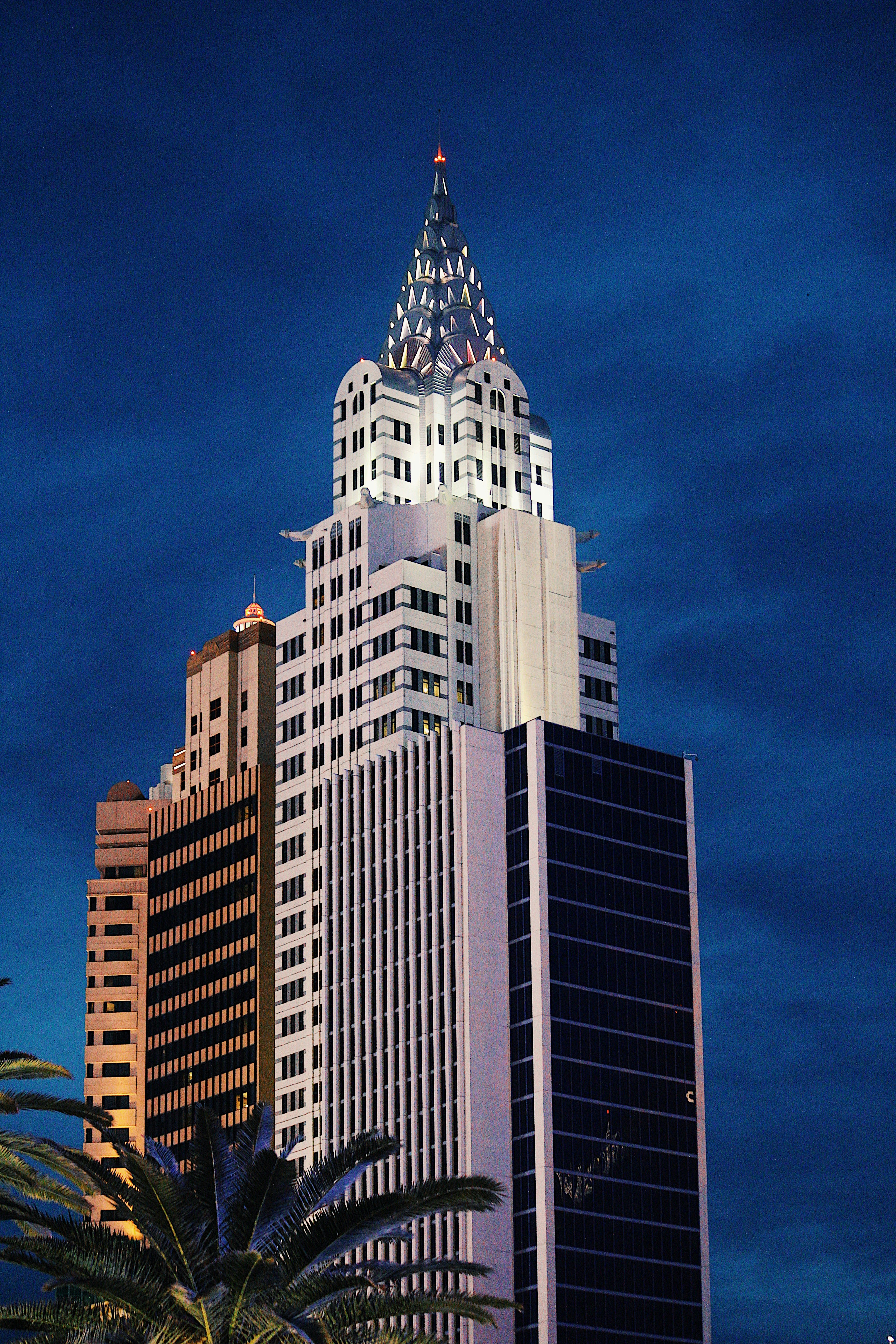 Art Deco skyscraper illuminated against a twilight sky, showcasing intricate architectural details and modern design elements.