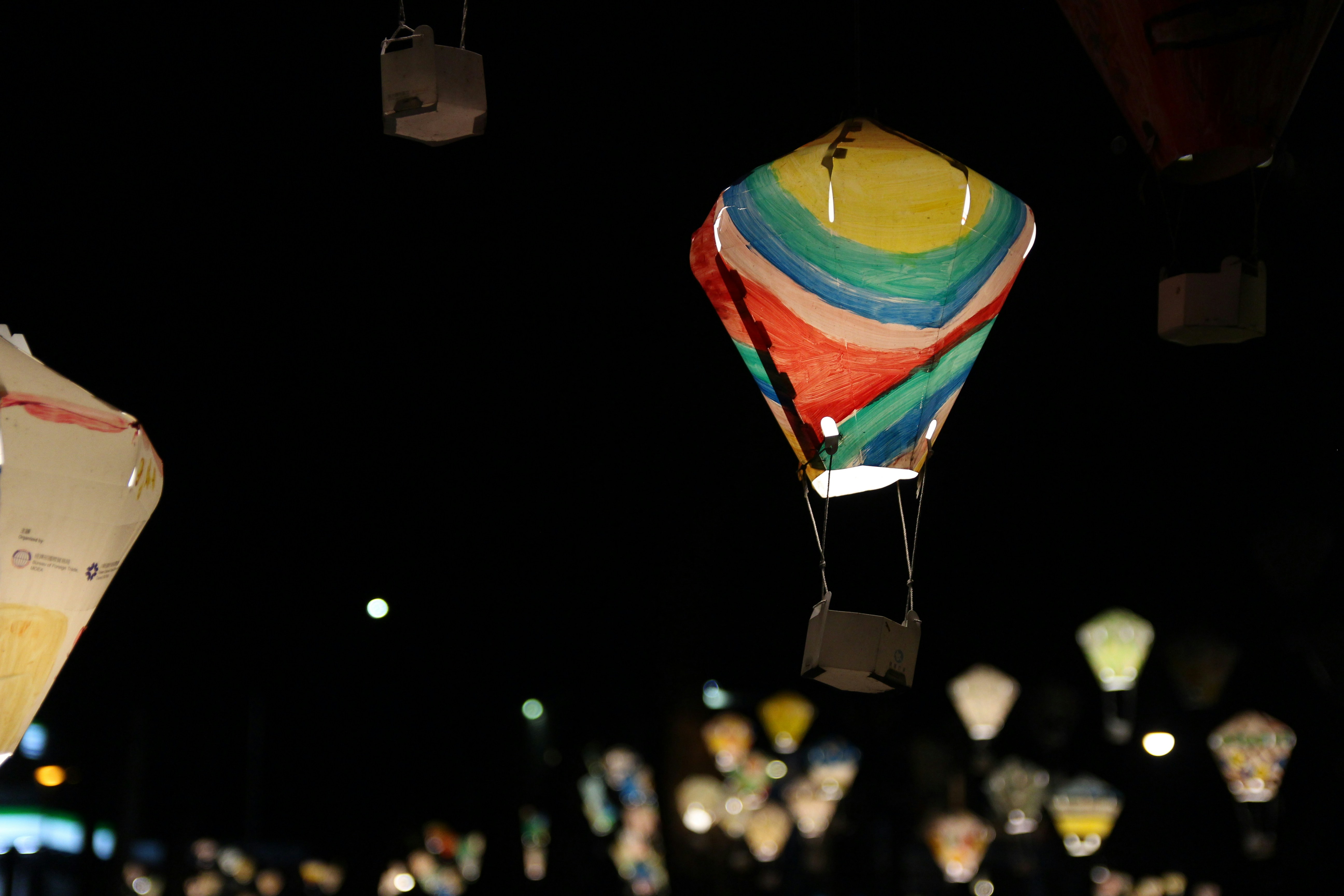 A Painted Lantern Soars Above a Sea of Night-Born Lights