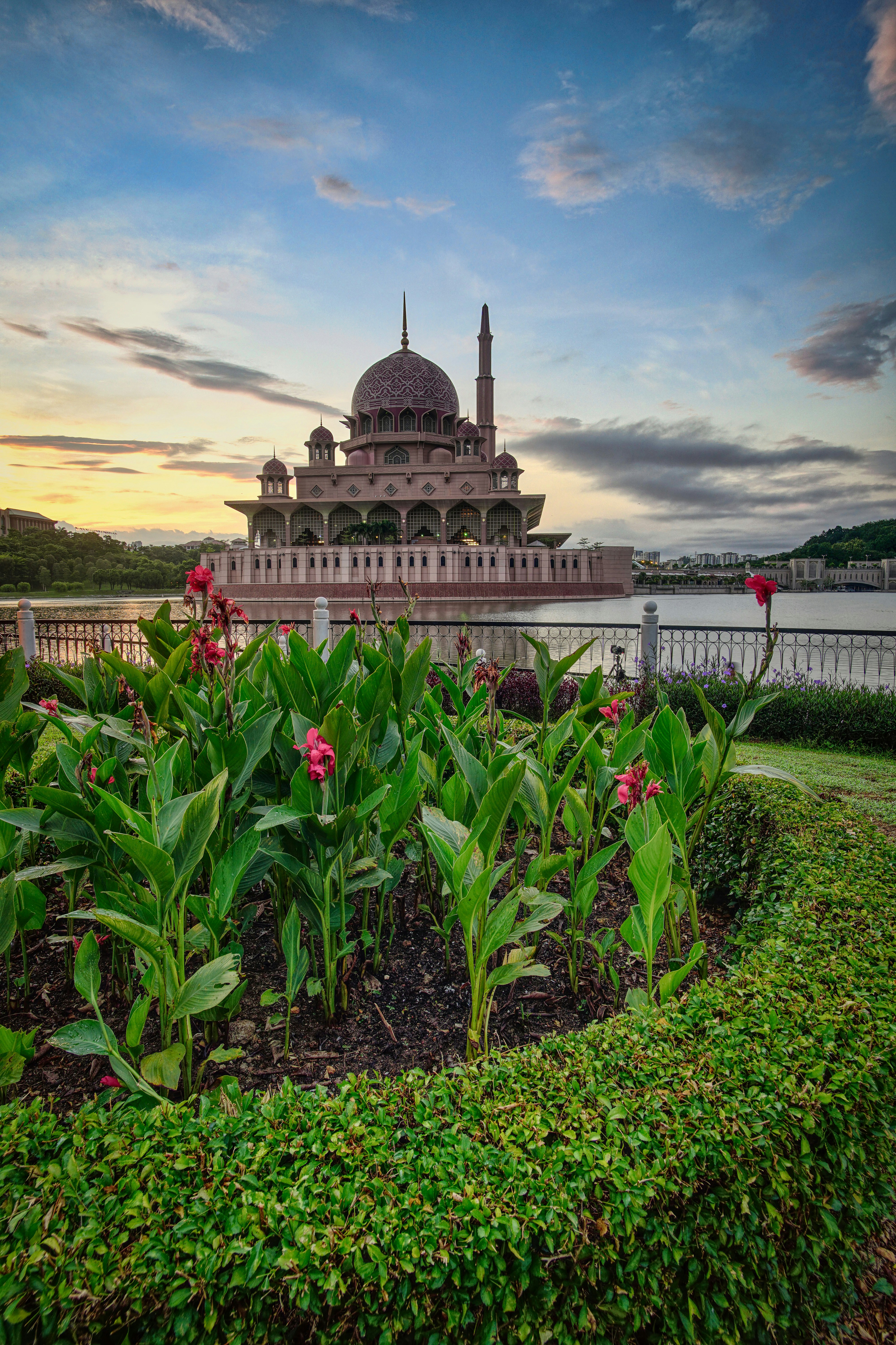 Sunset Over a Pink-Domed Riverside Monument, Framed by Lush Garden Edges