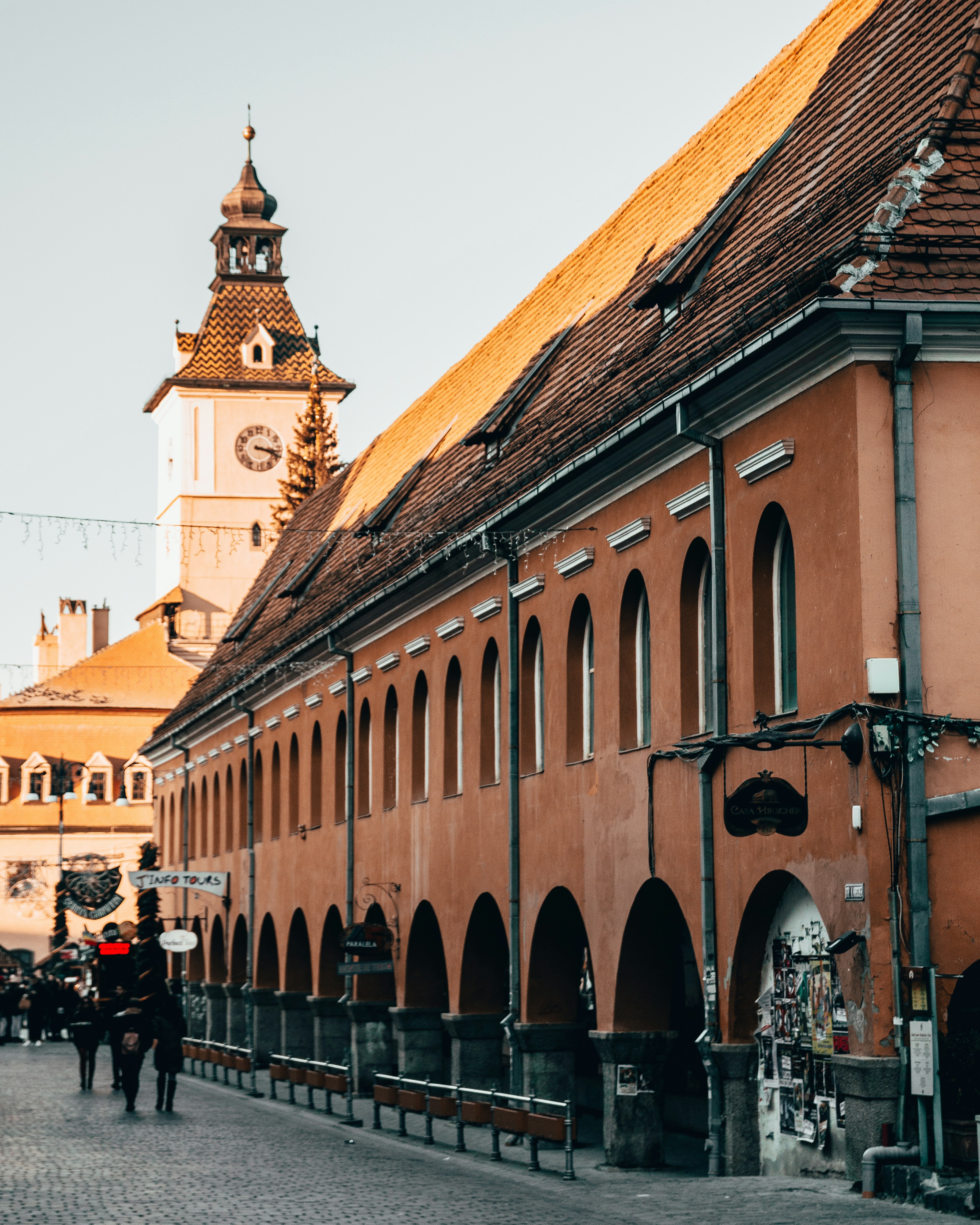 Evening Light Over Arcaded Street Framing a Clock Tower