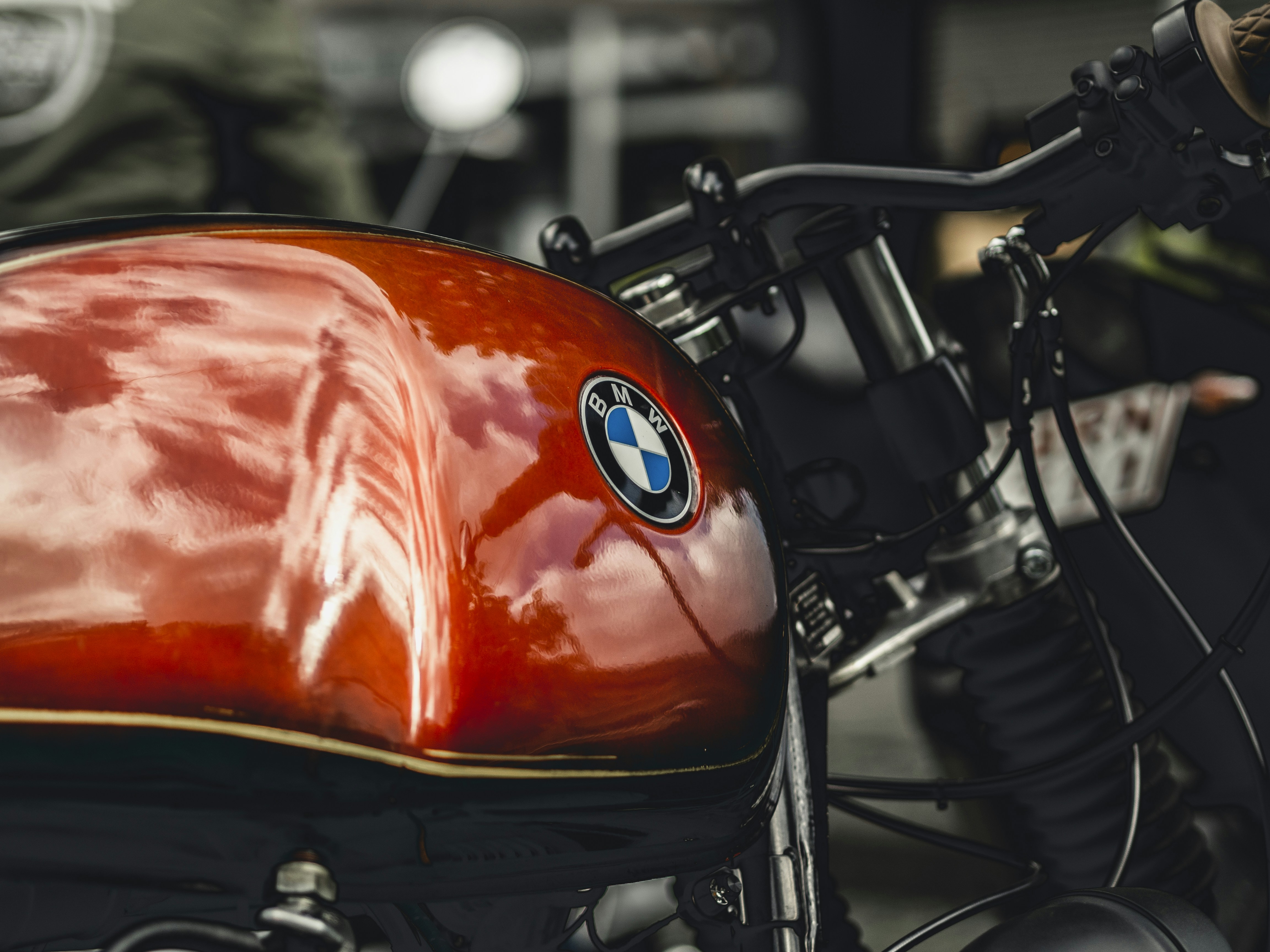Glossy Ember on Steel: BMW Emblem Anchored in a Crimson Tank