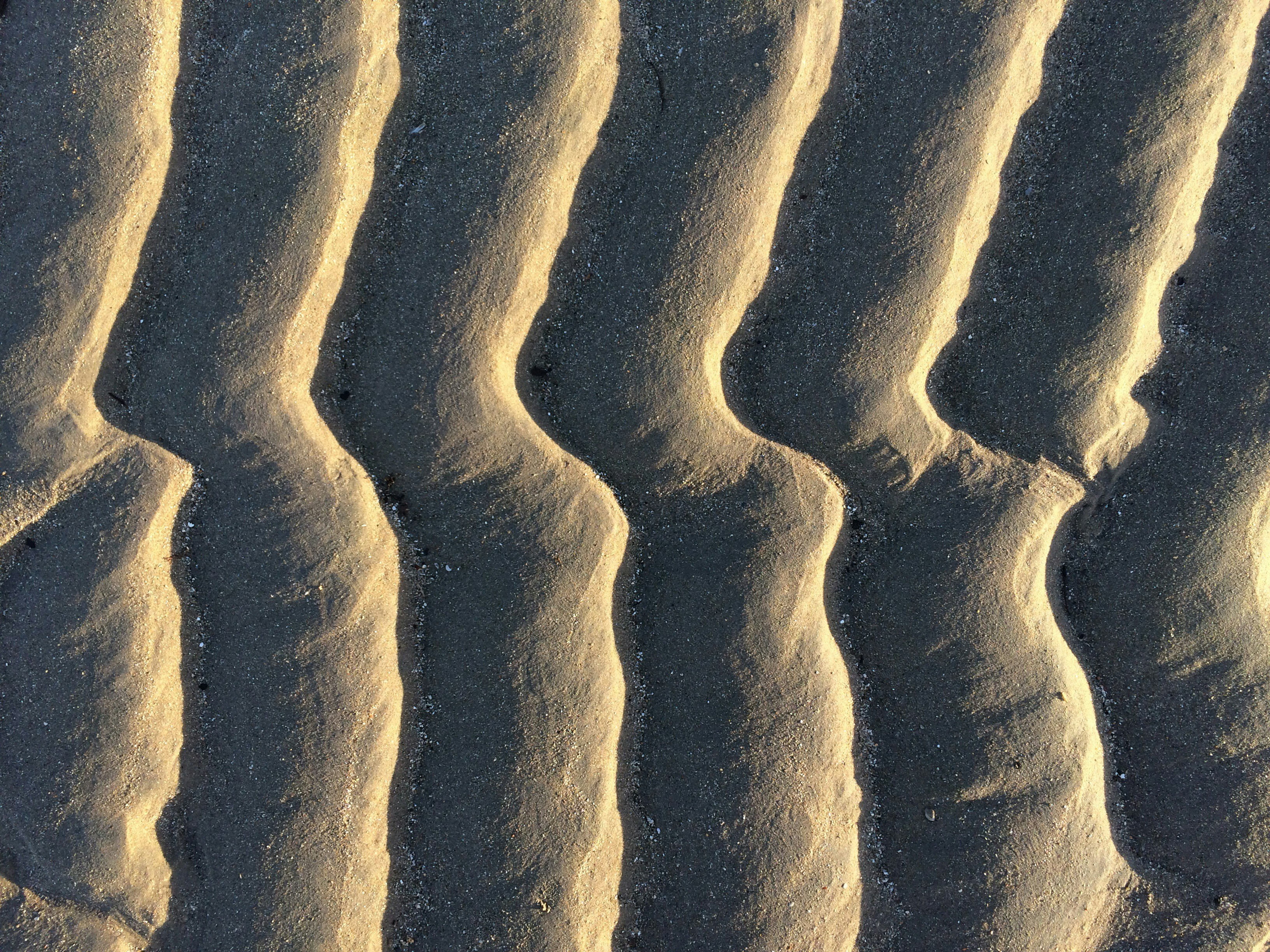A close up of a sand dune with wavy lines photo – Free Sand Image on ...