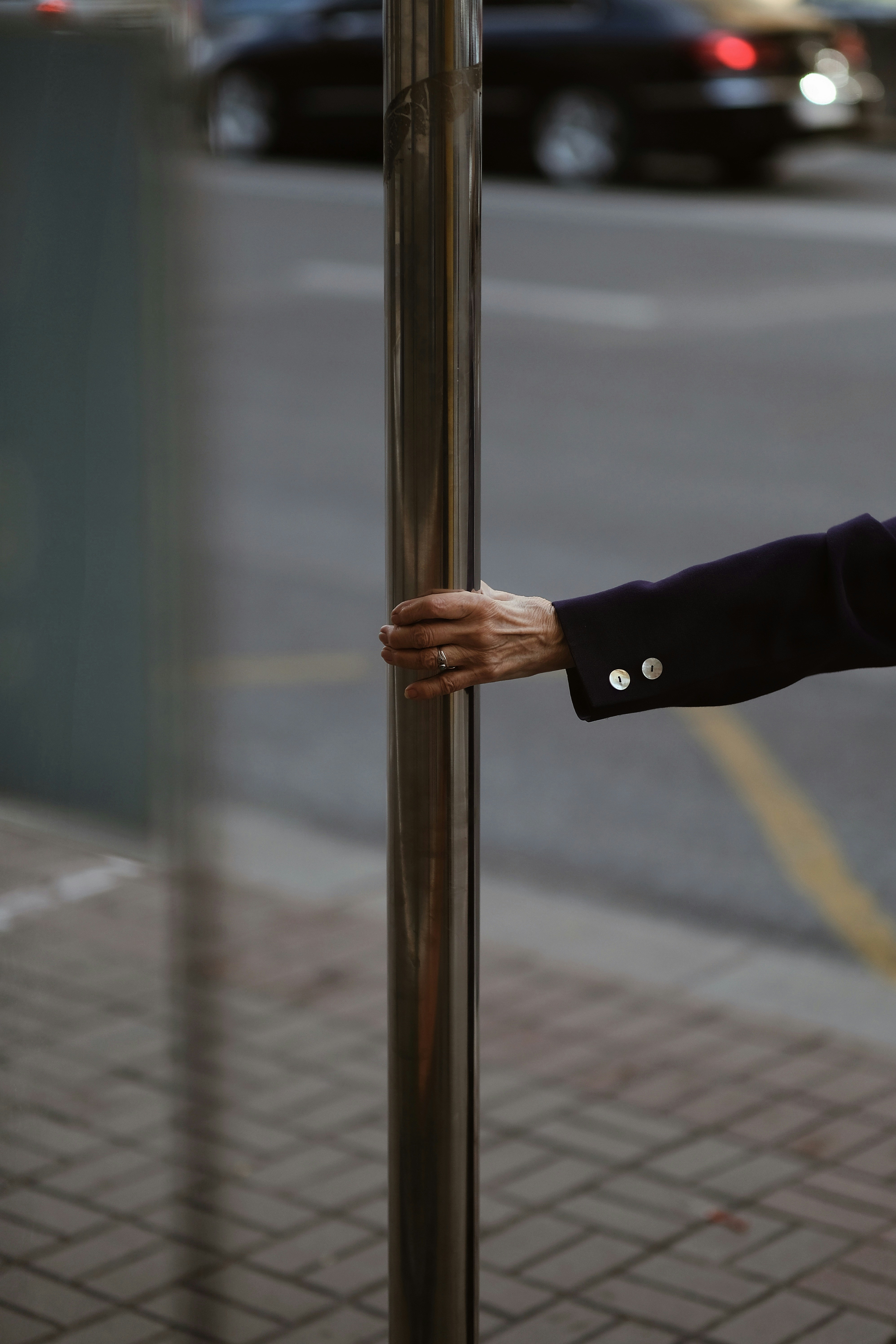City Hand on Steel: A Quiet Portrait Amid Moving Traffic