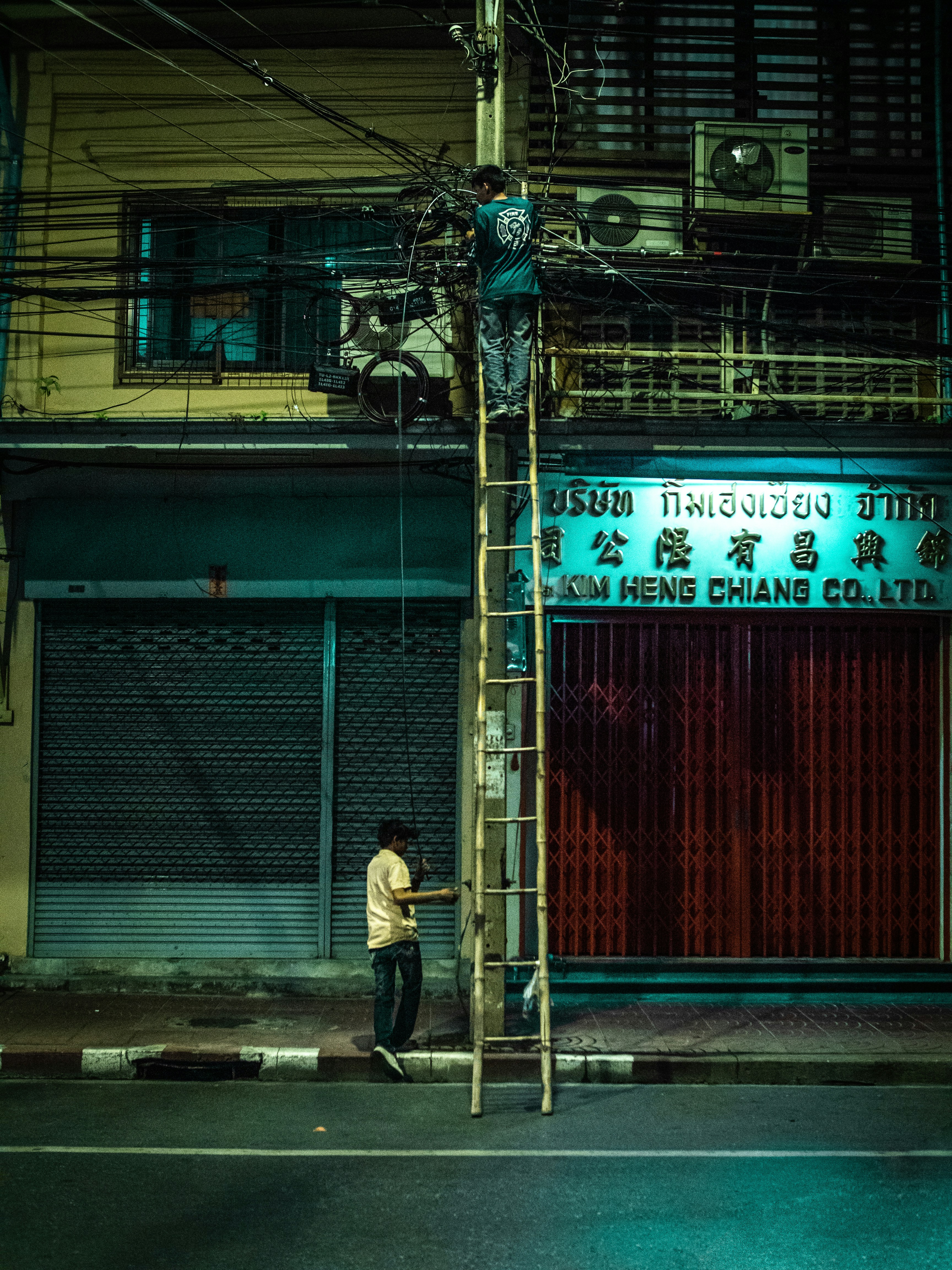 Pole-Top Vigil: Night Wiring on a Neon-Lit Street