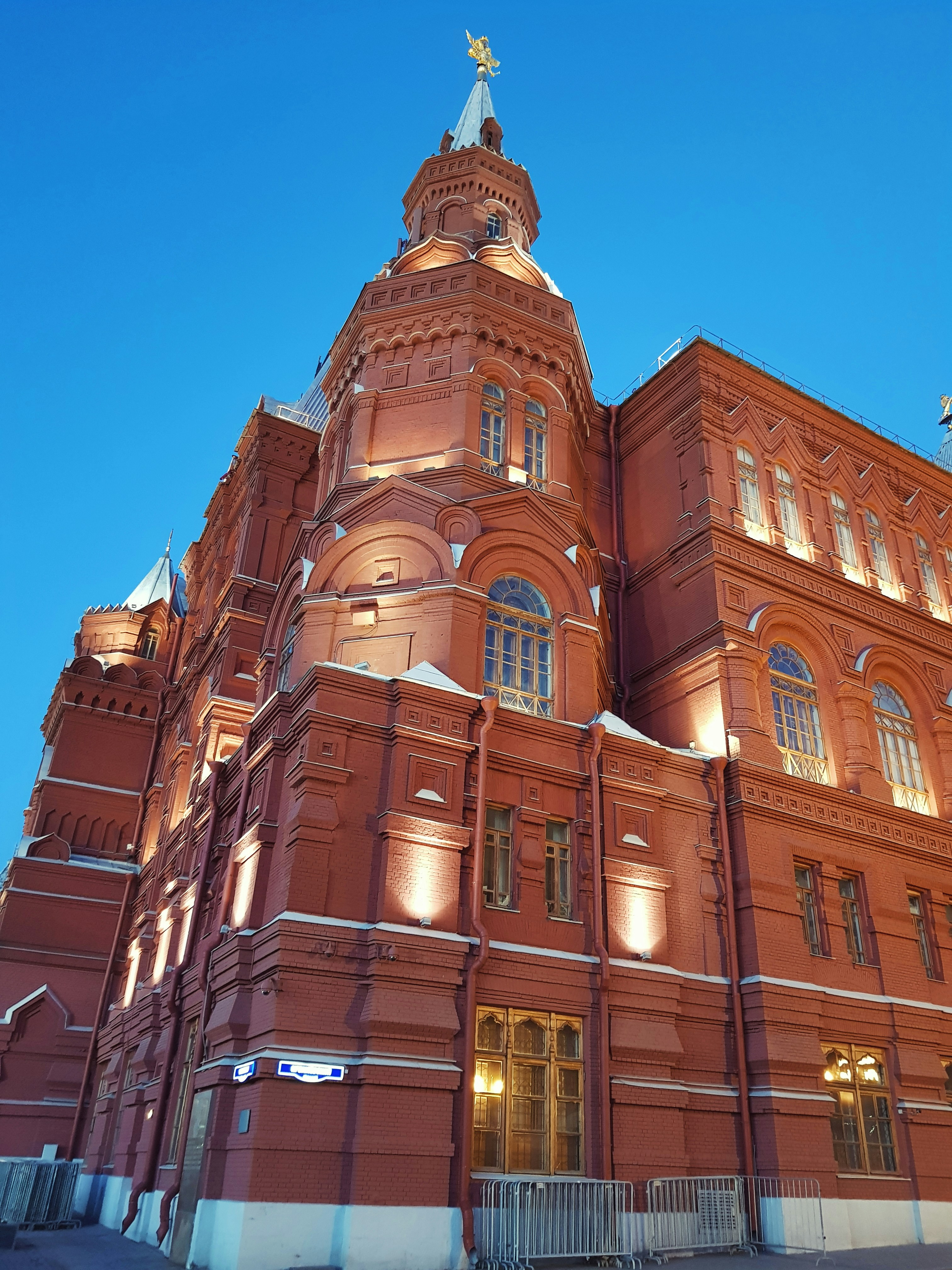 Towering Red Brick: Sunlit Facade Reaching Toward a Clear Sky