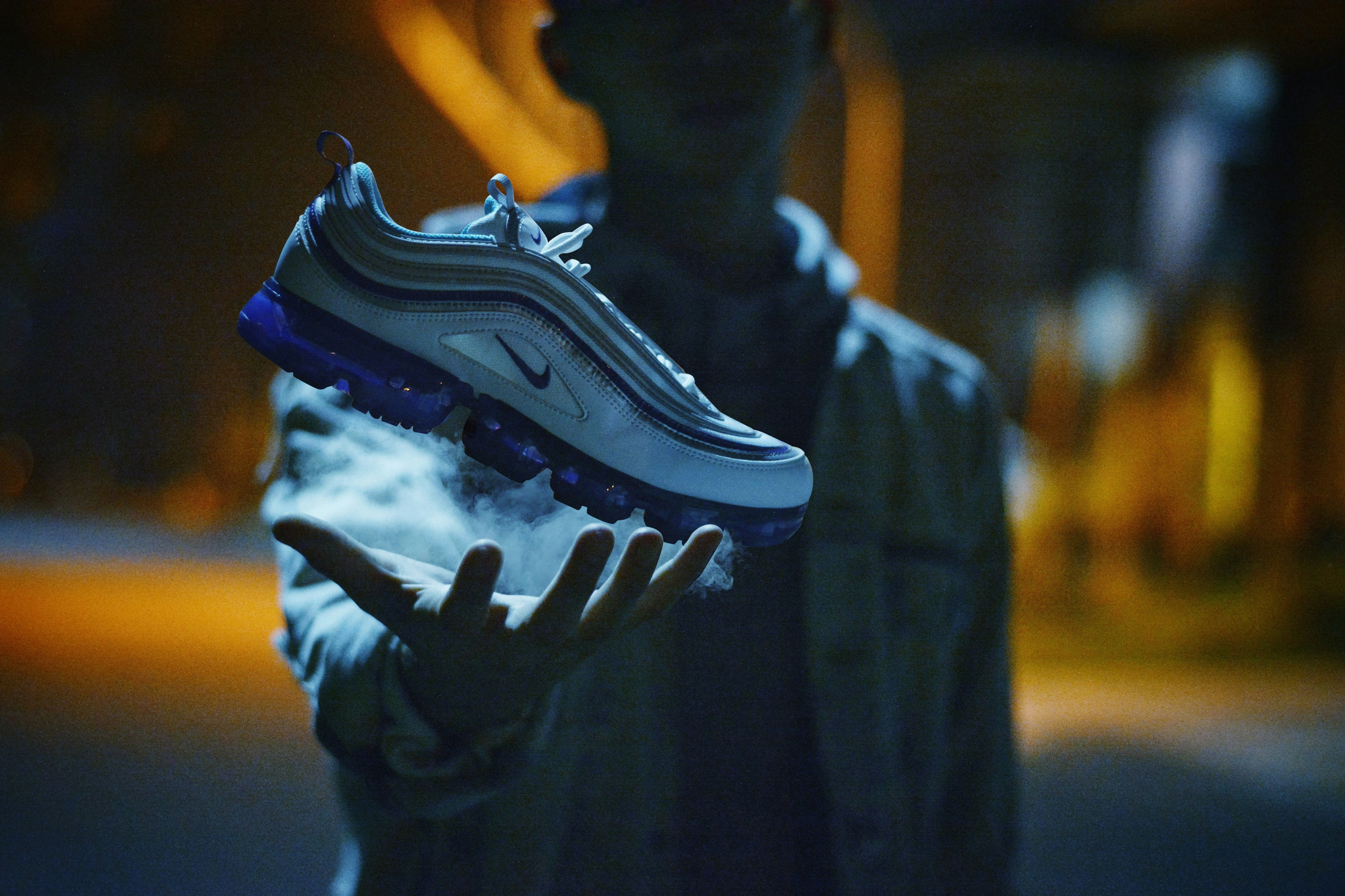 Neon Night Sole: A Handheld Sneaker Amid City Glow