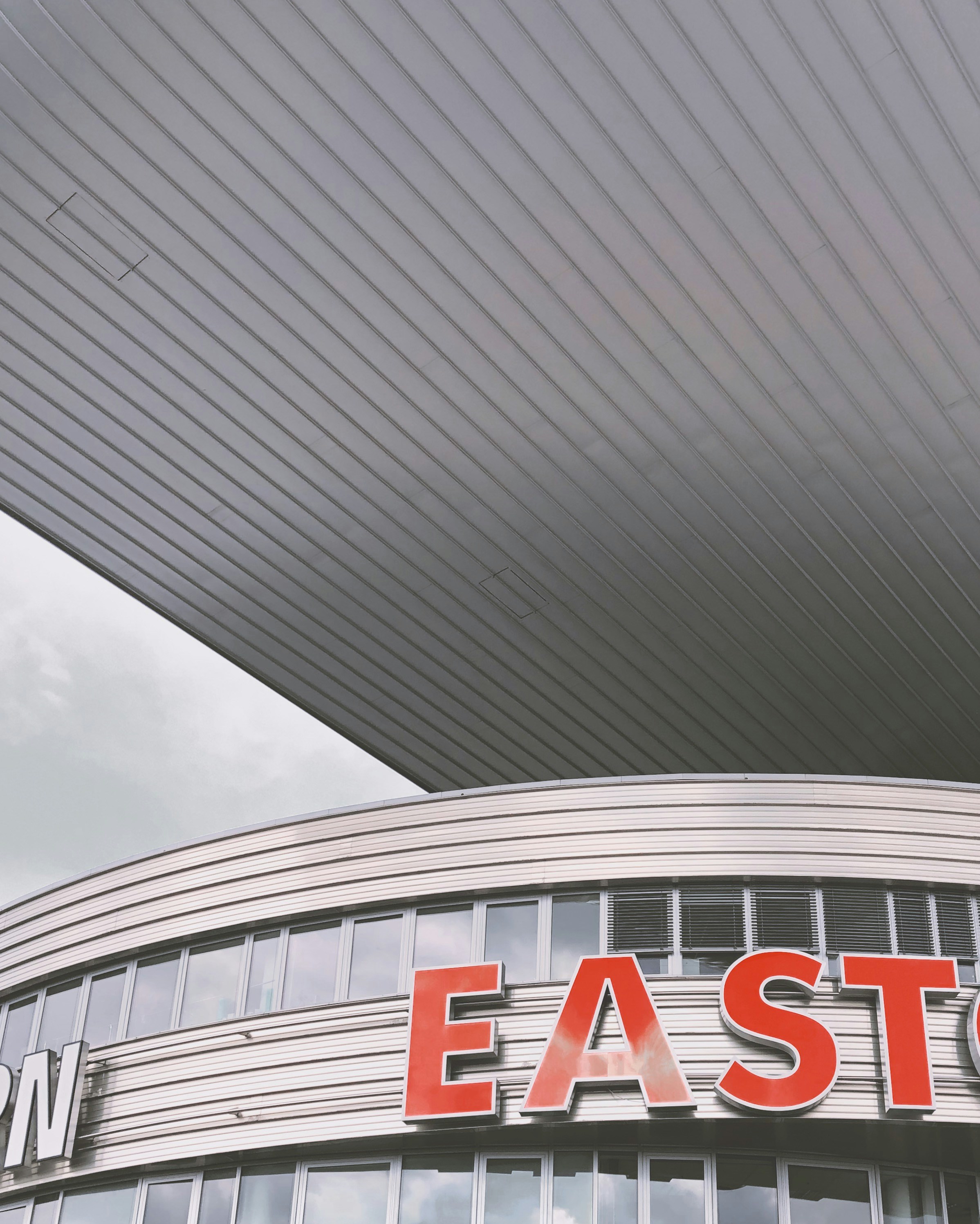 Curved Facade and Bold East Sign Under Suede Overhang