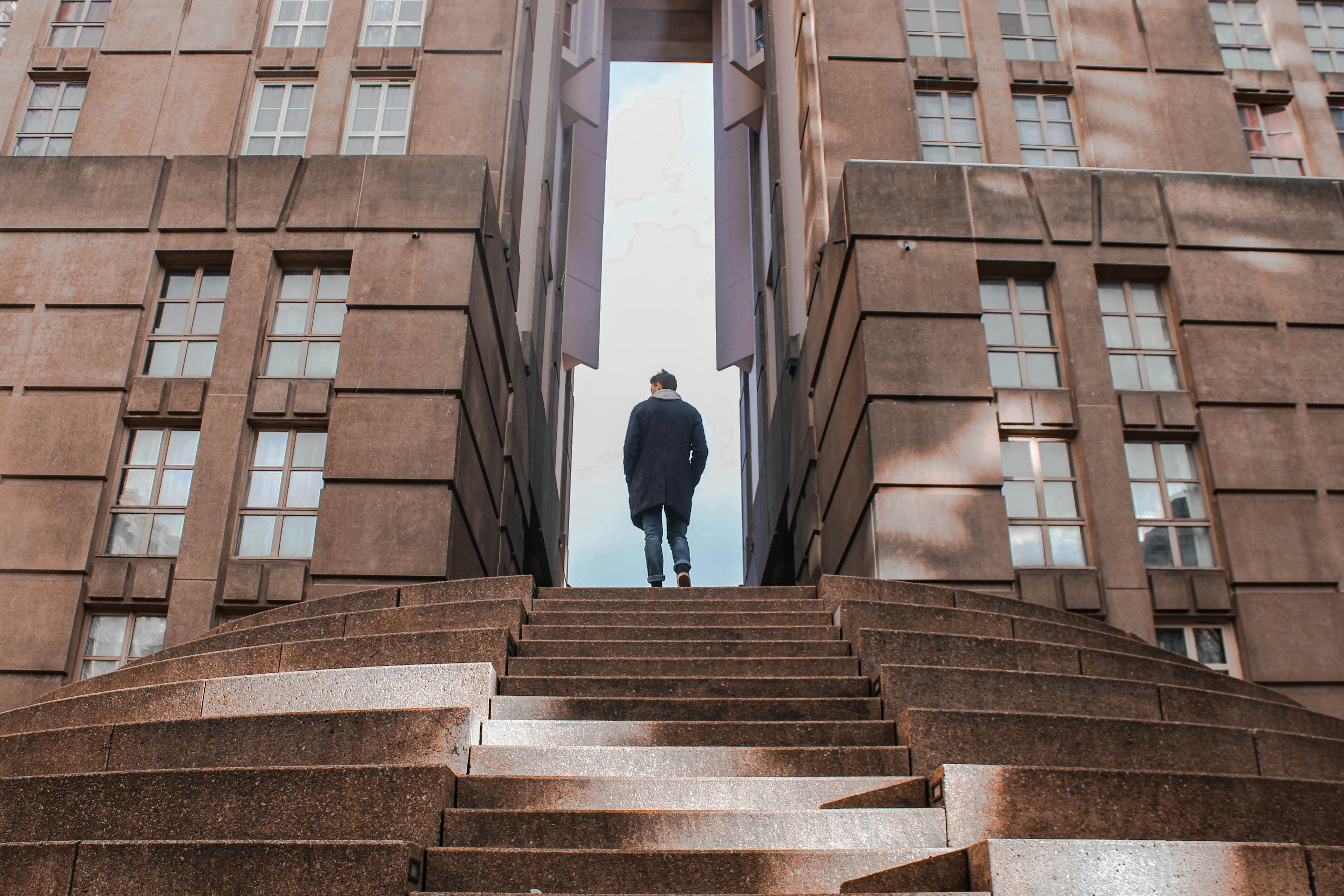 Person standing between concrete building at daytime photo – Free ...
