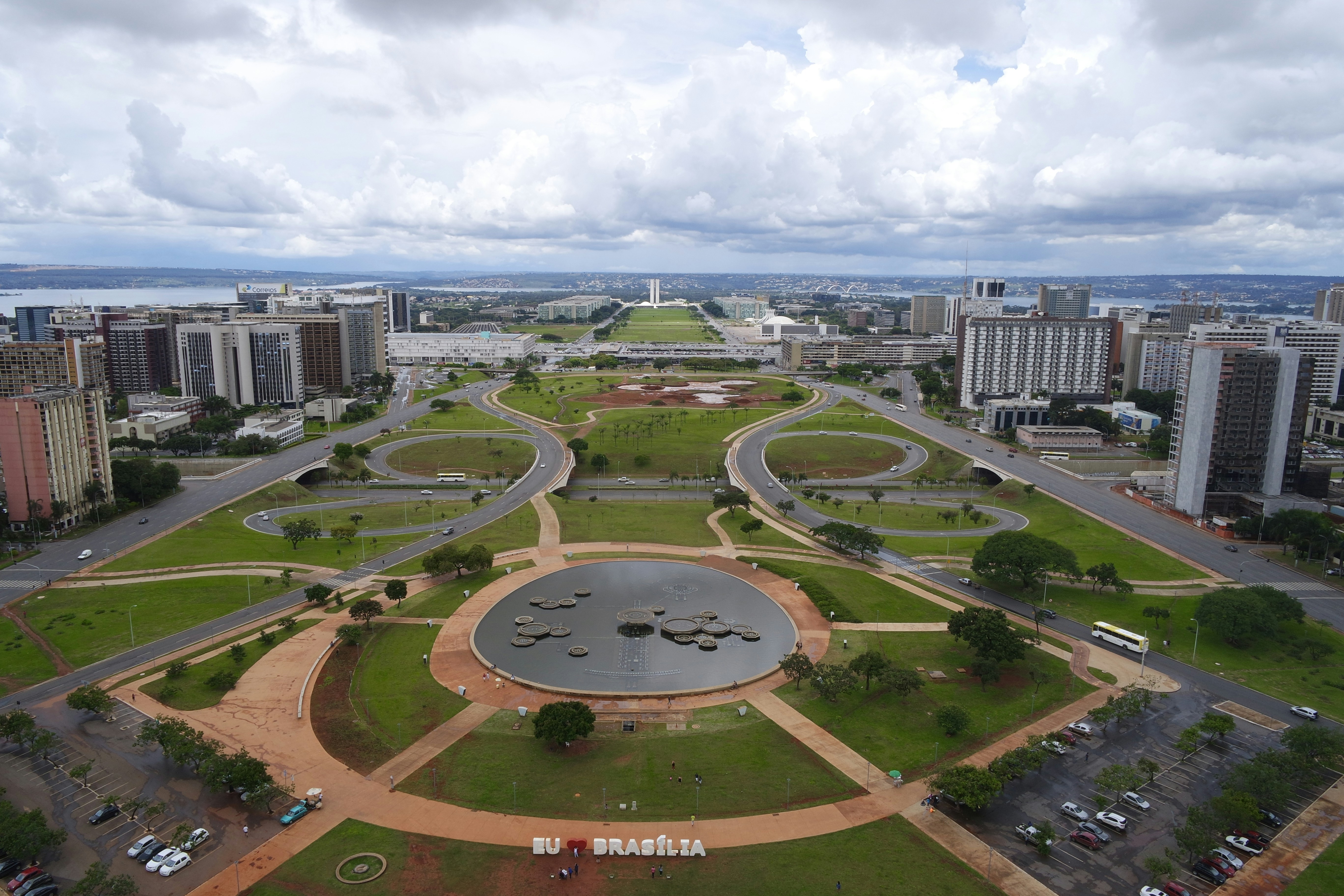 Aerial view of Brasília showcasing its unique urban design with circular green spaces and modern architecture. The scene captures the essence of the city’s planned layout.