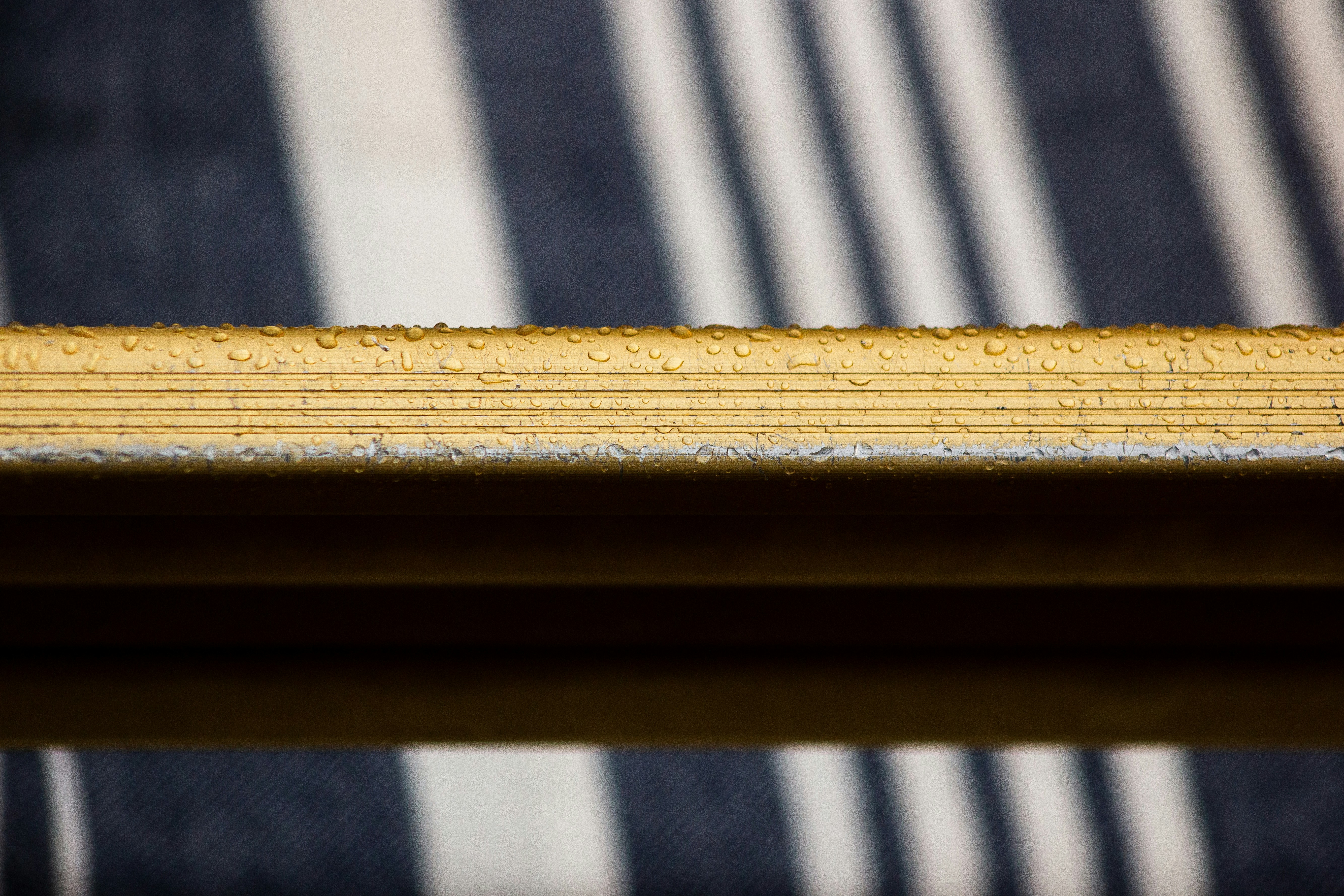 Beads on a Golden Edge: Macro Moment Against Striped Fabric