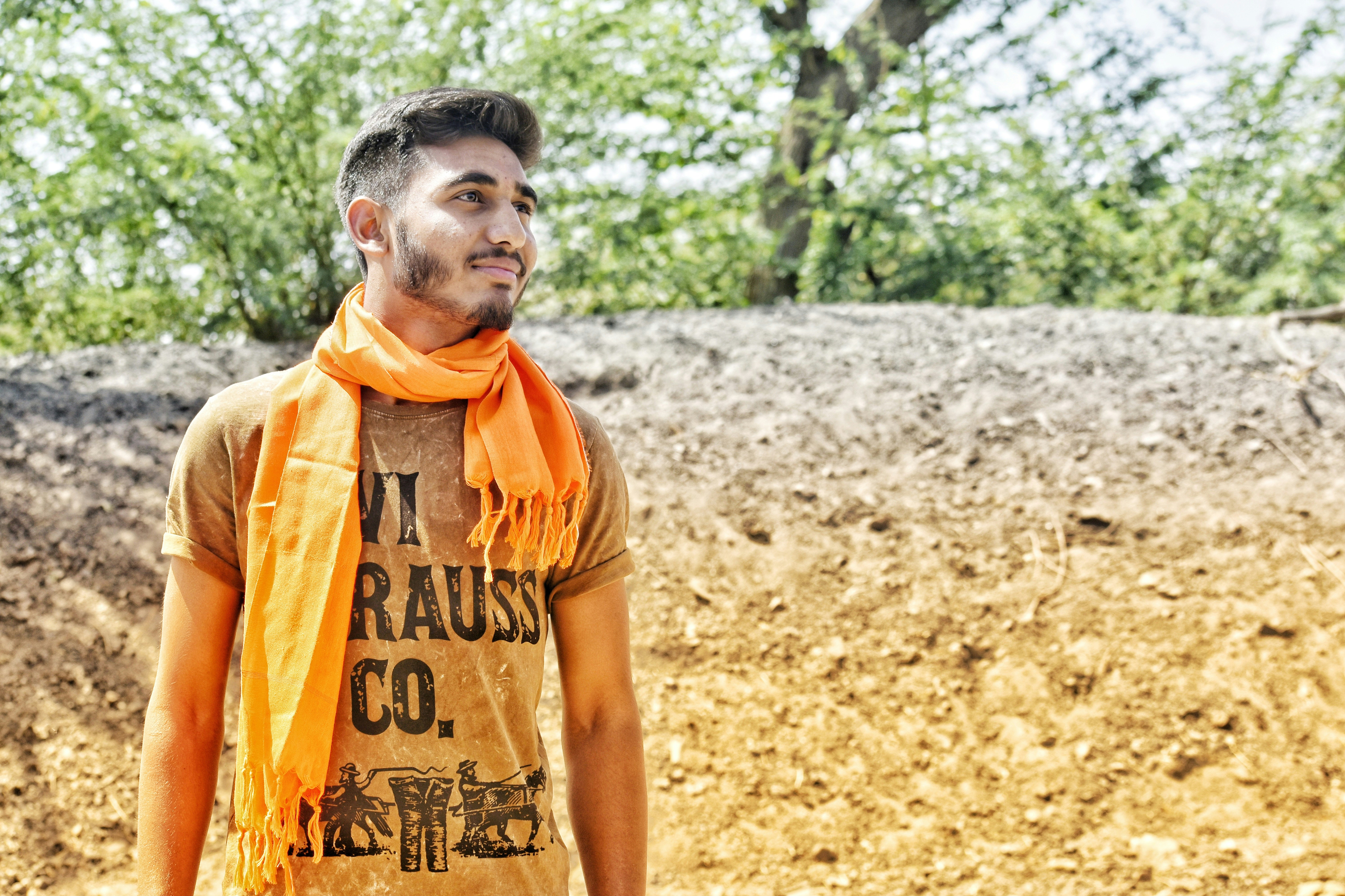 man in brown Levi Strauss Co. crew neck t-shirt with orange scarf around neck