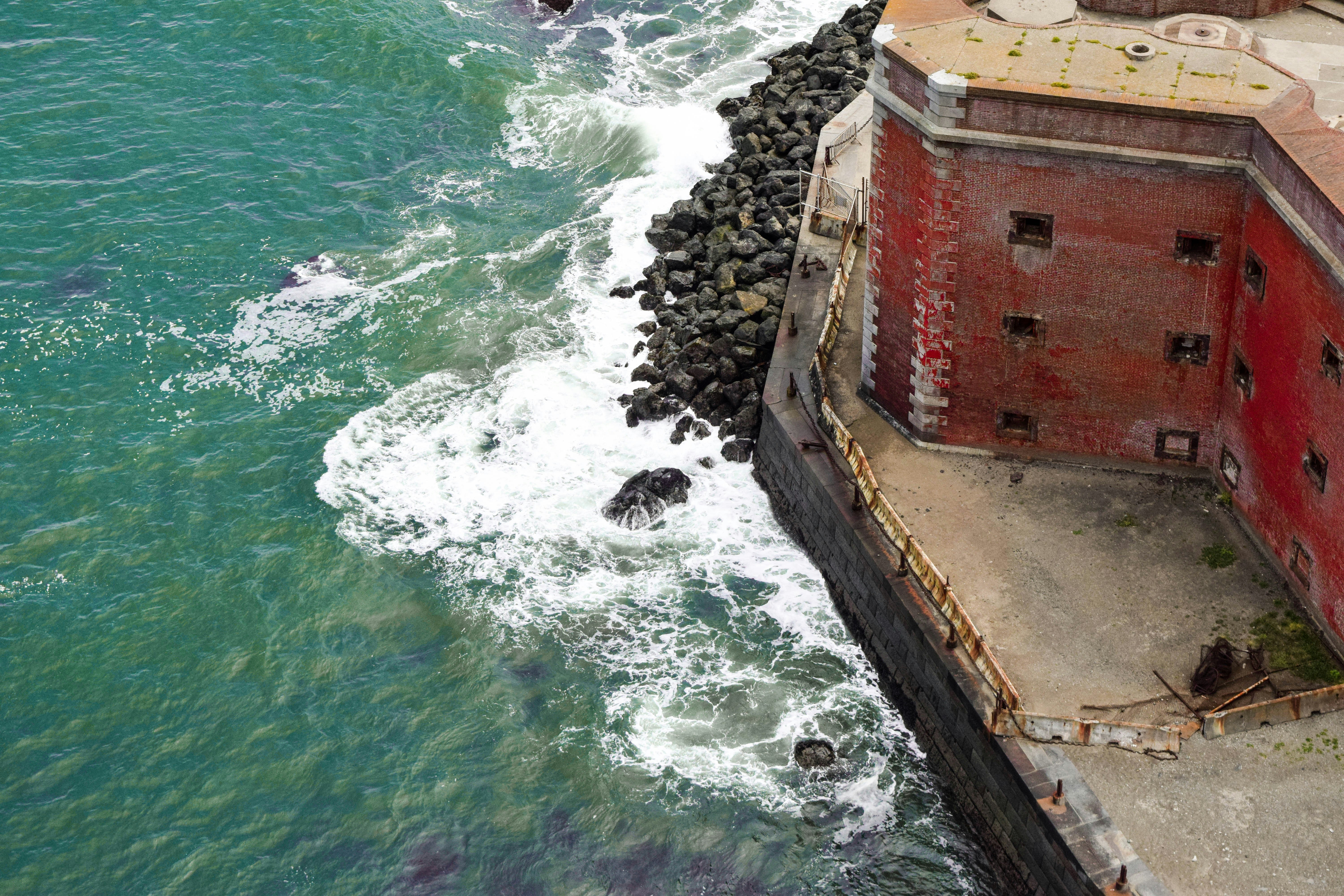 Red seawall fortress hugging the turquoise edge