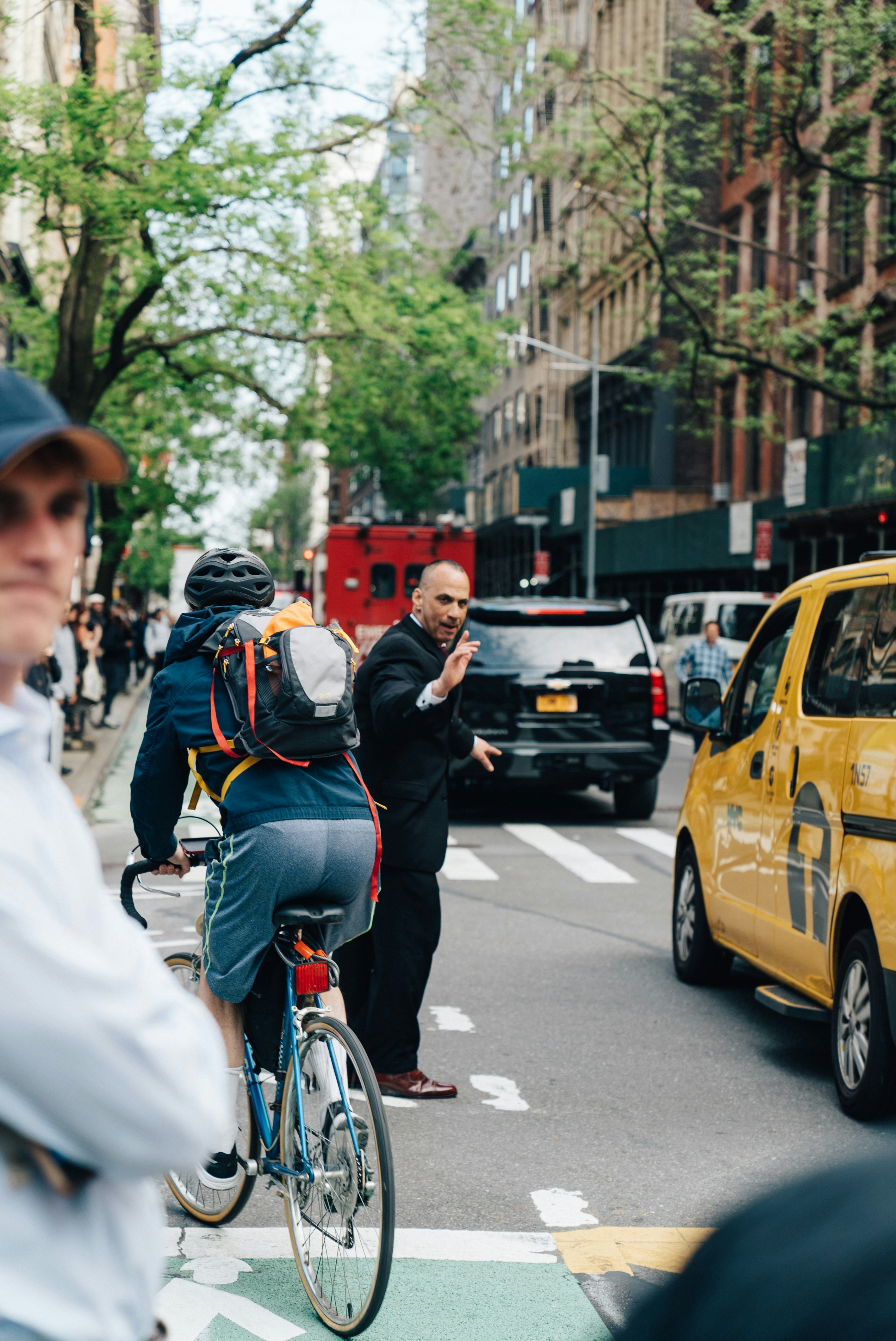 Crossing City Pulse: A Cyclist Pauses as a Transit Moment Unfolds