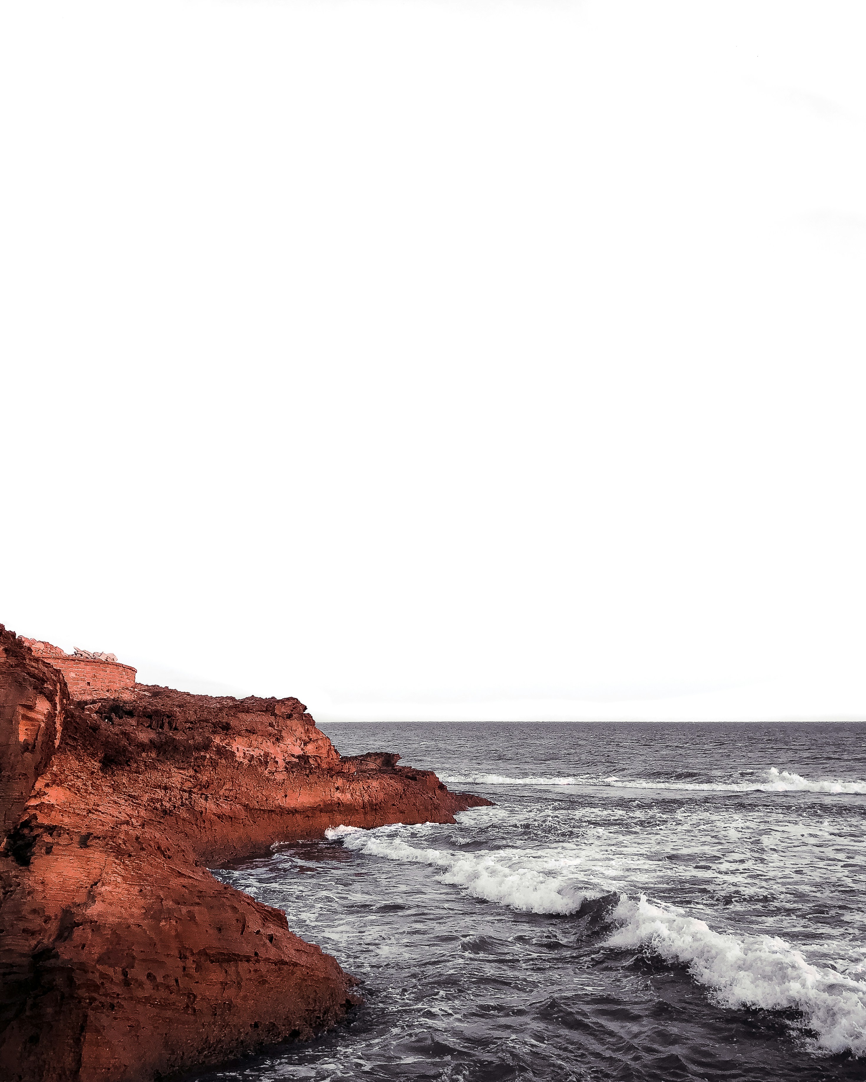 Crimson Cliffs Fringing a Quiet Atlantic Horizon