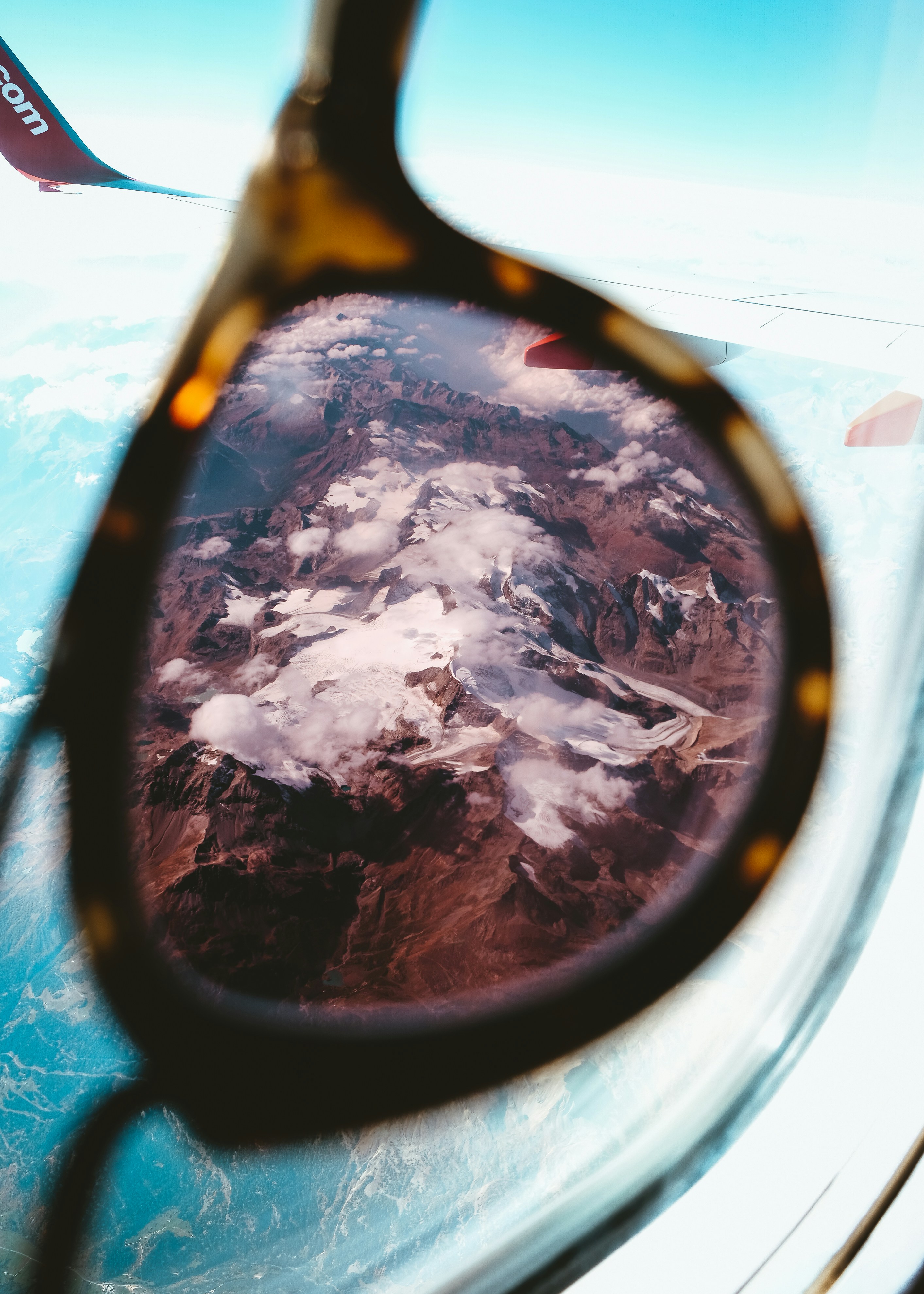 Mountain Mirror: Aerial Ridge Framed by Sunglass Lens in Flight