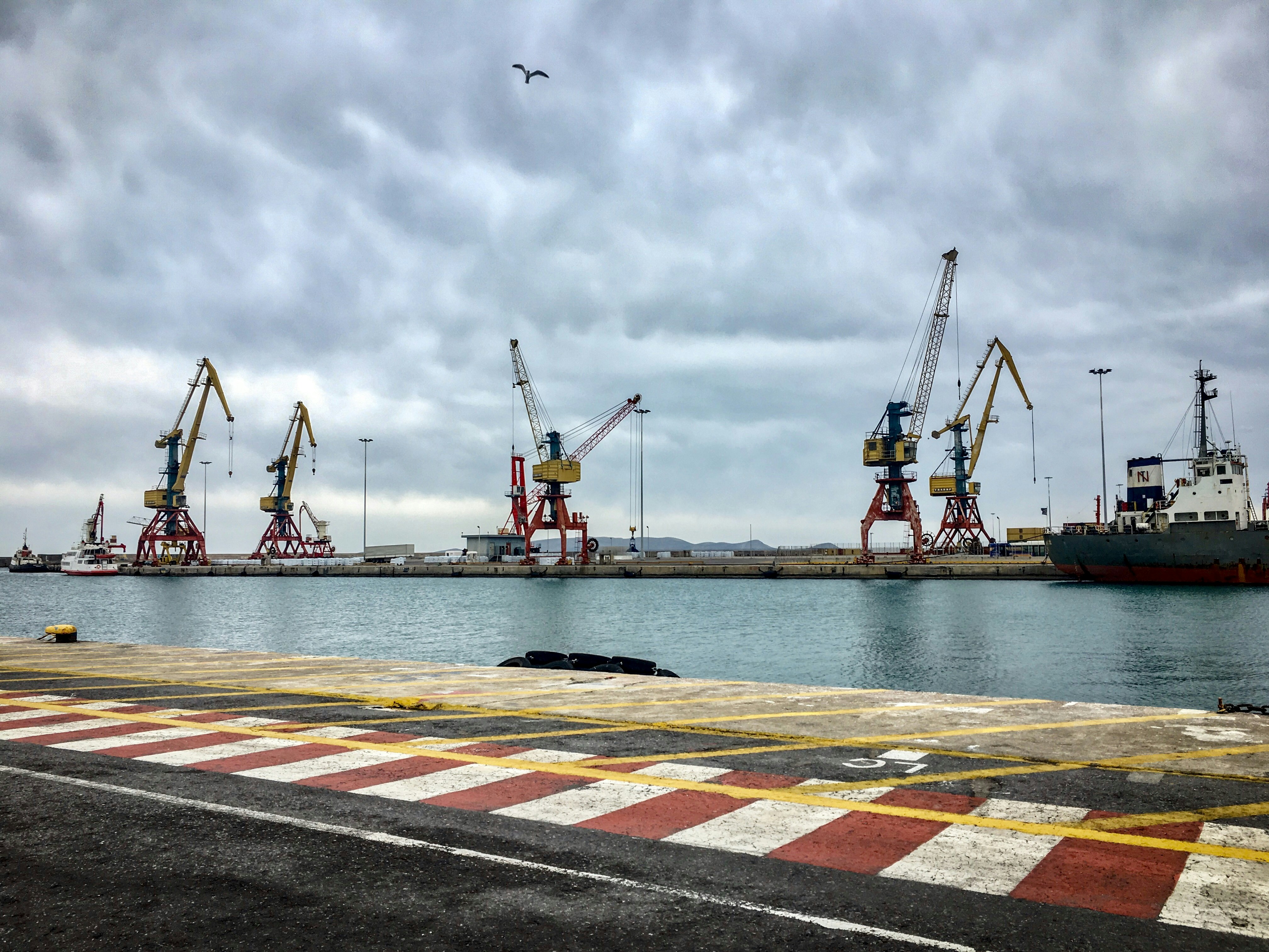 crane towers beside body of water