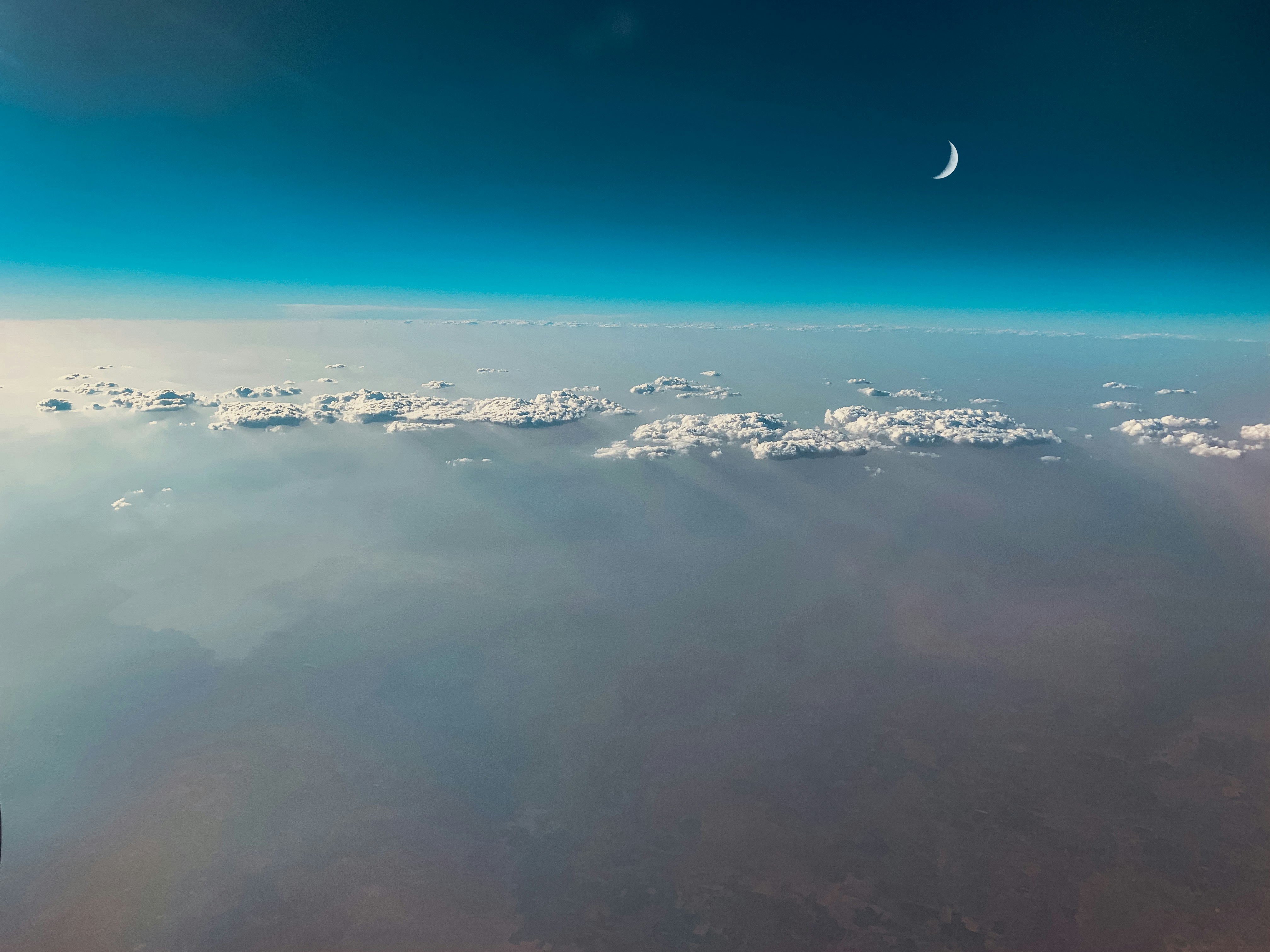 Crescent Above the Cloud Sea: A Quiet Sky from 30,000 Feet