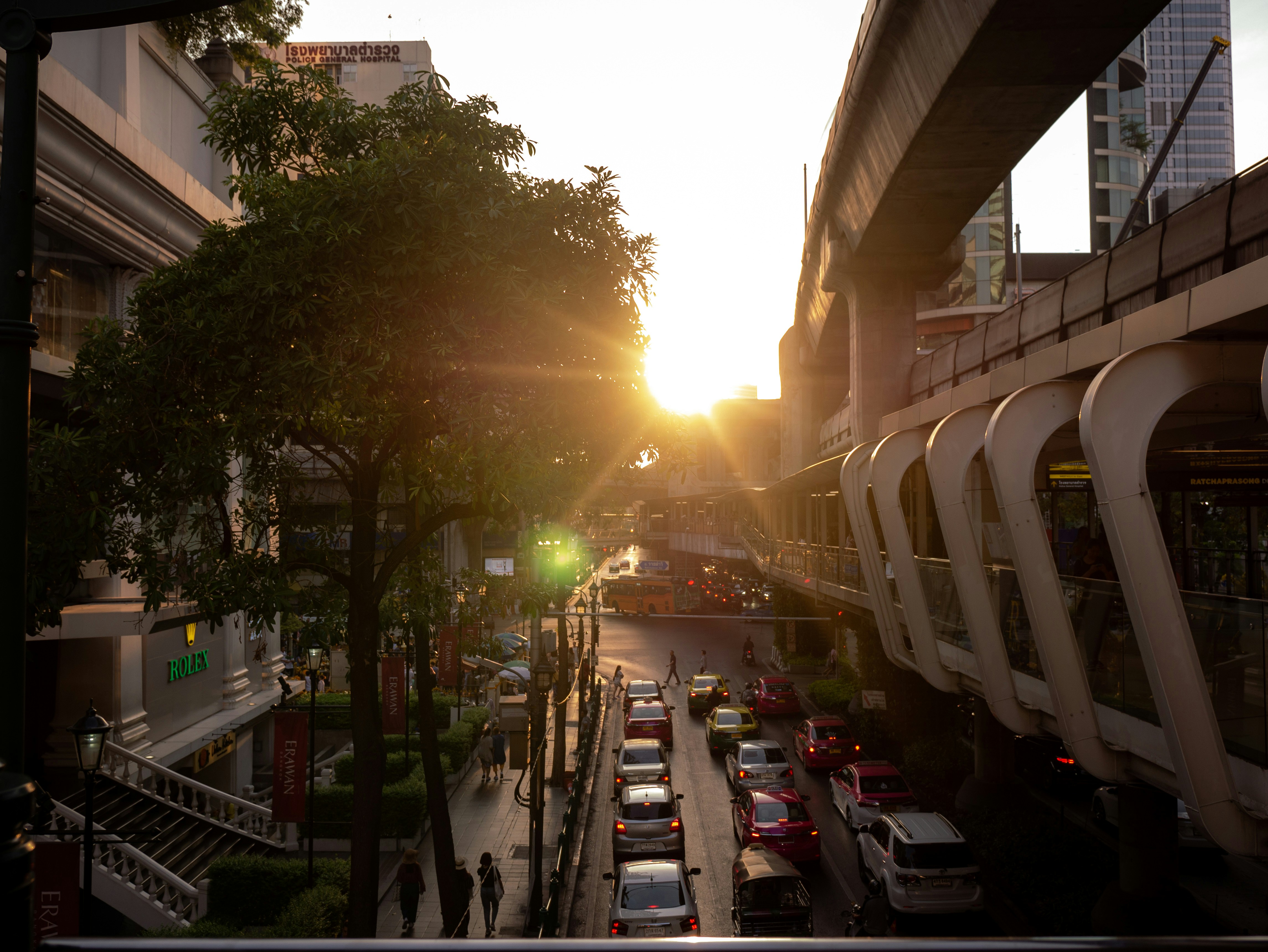Sunlit City Corridor: Street scene beneath elevated rails at golden hour
