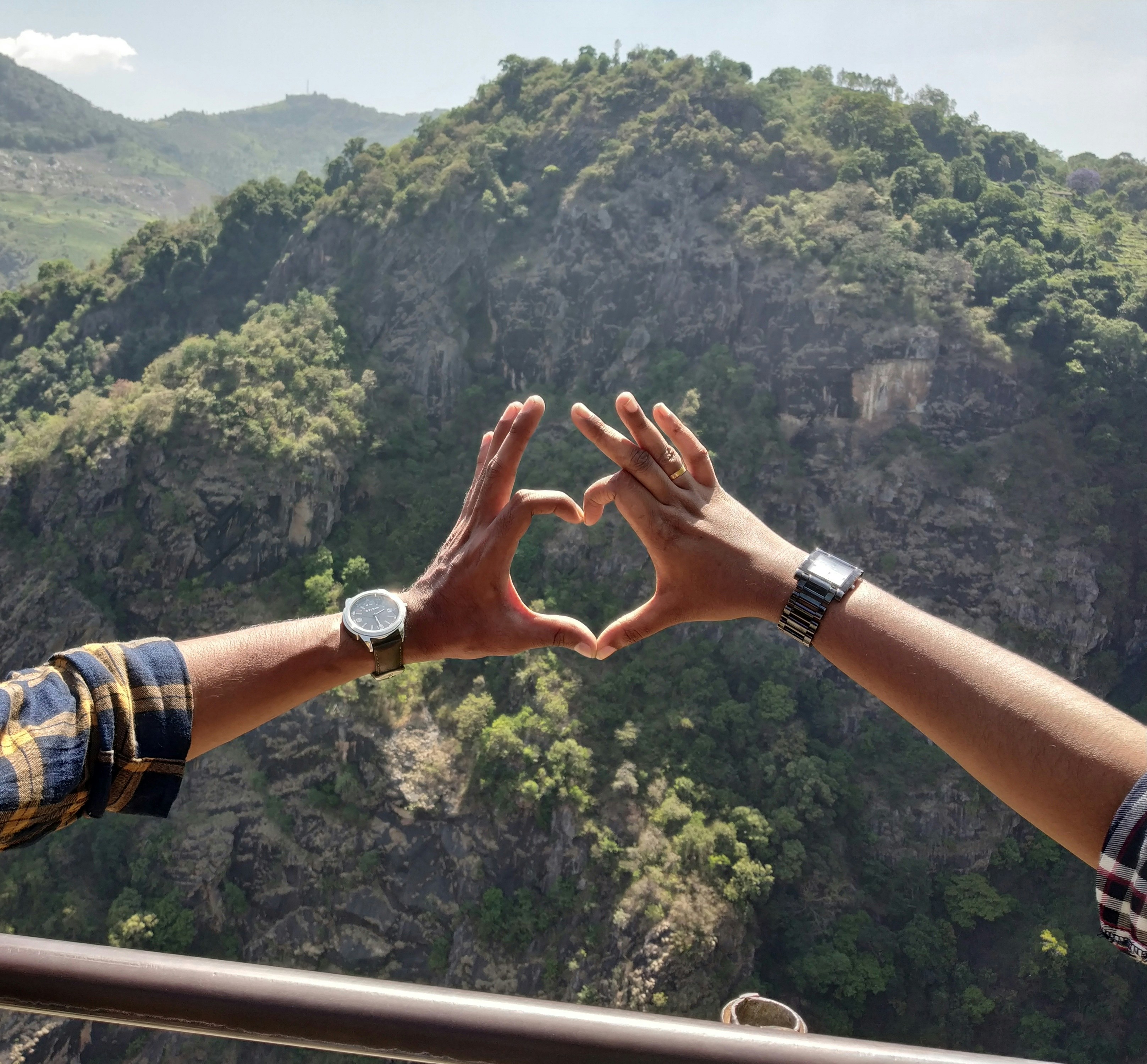 Hands Form a Heart Over a Mountain Canyon