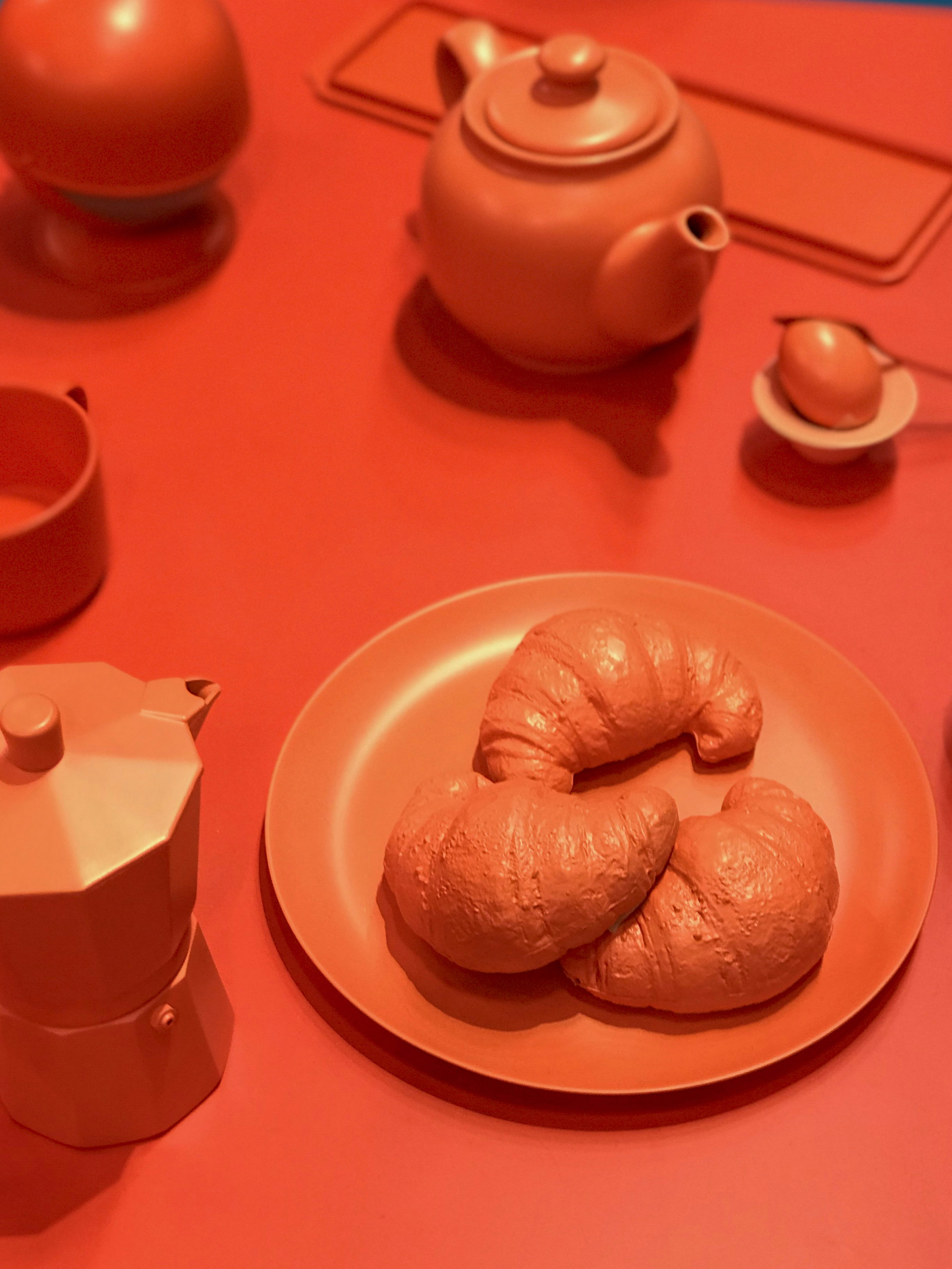 Crimson Dawn Breakfast: Croissants Rest on a Plate Under a Warm Orange Glow