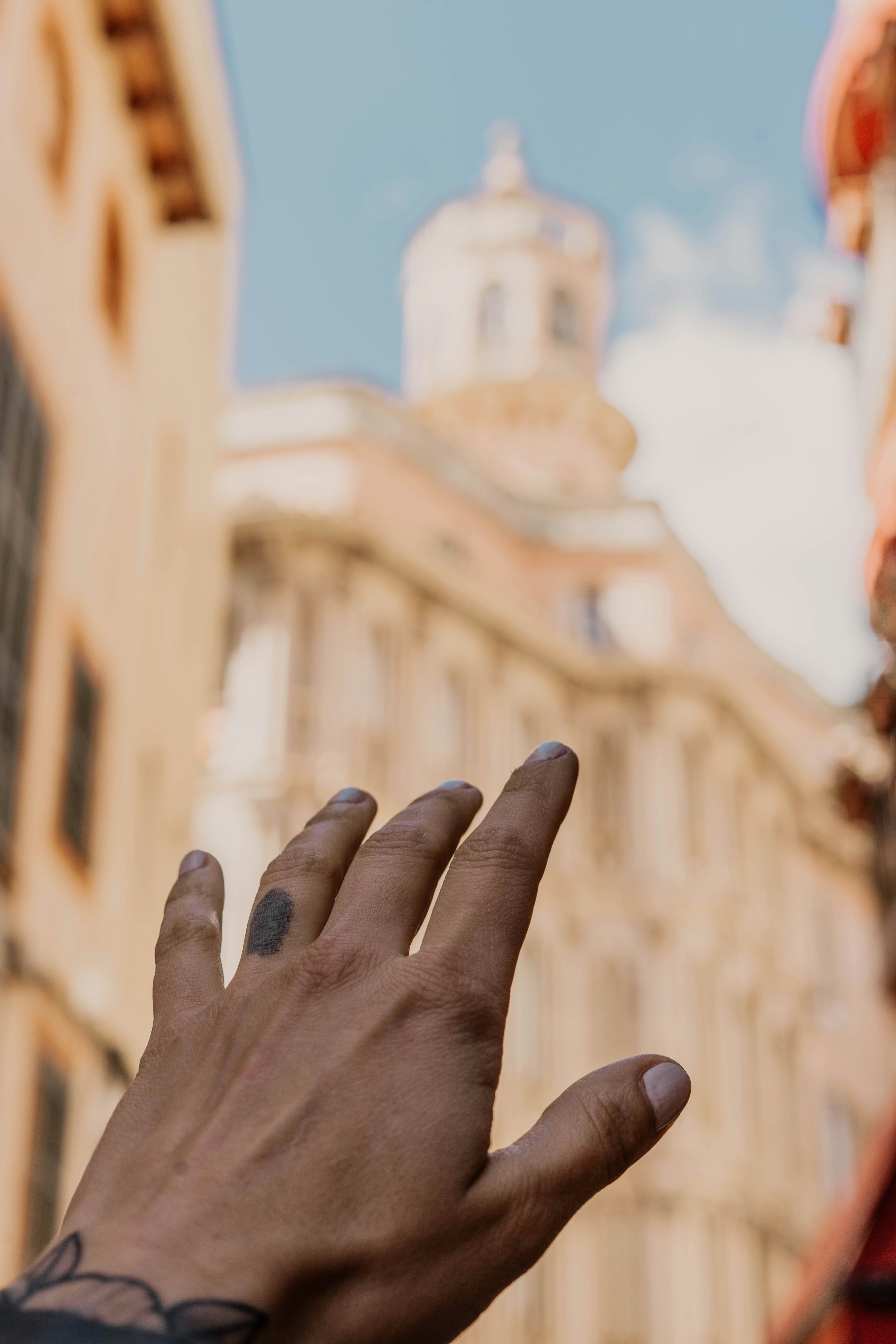 Outstretched Hand in Front of Historic Facade
